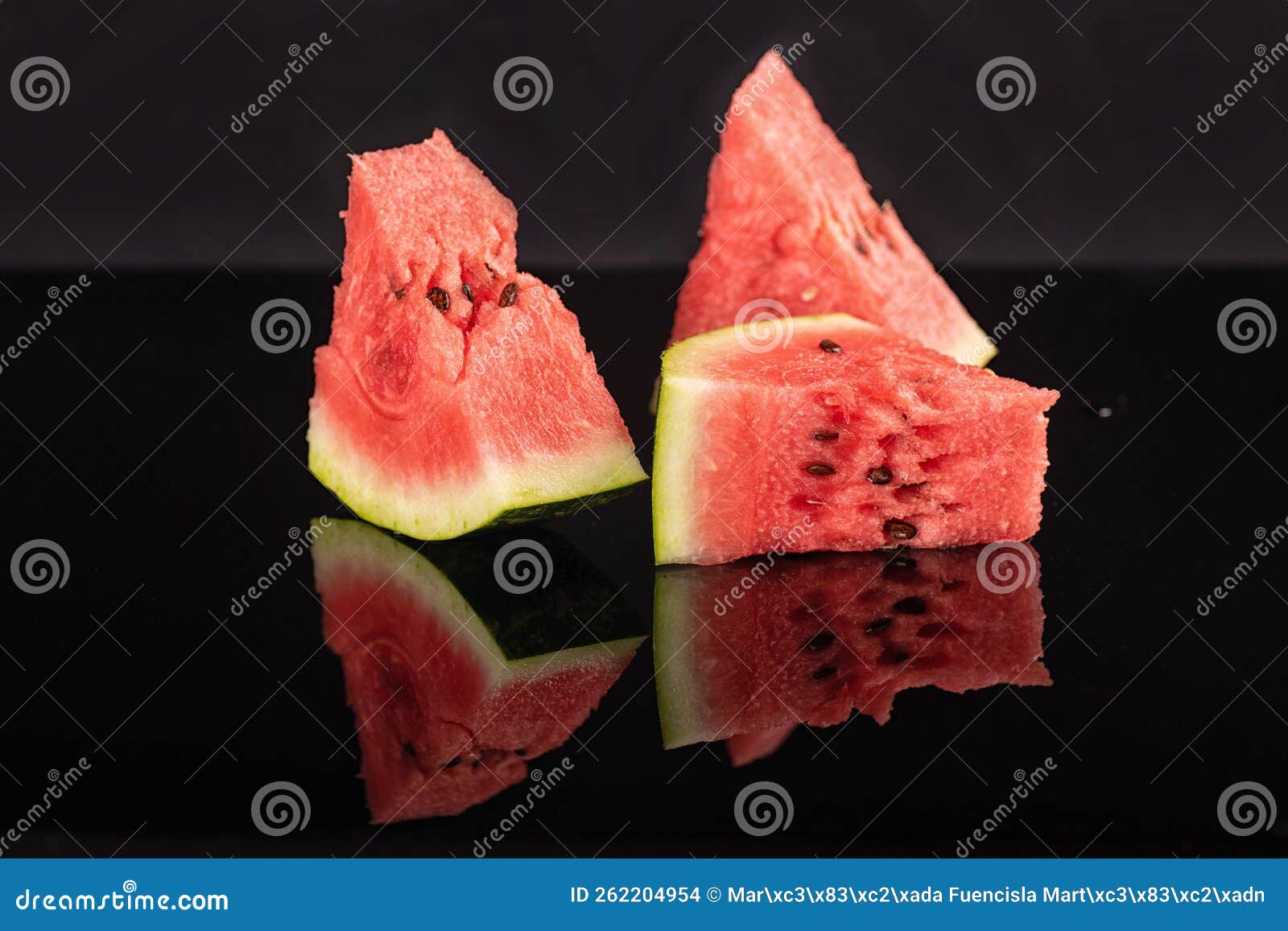 Row of Three Watermelon Slices on Black Reflective Surface Stock Photo ...