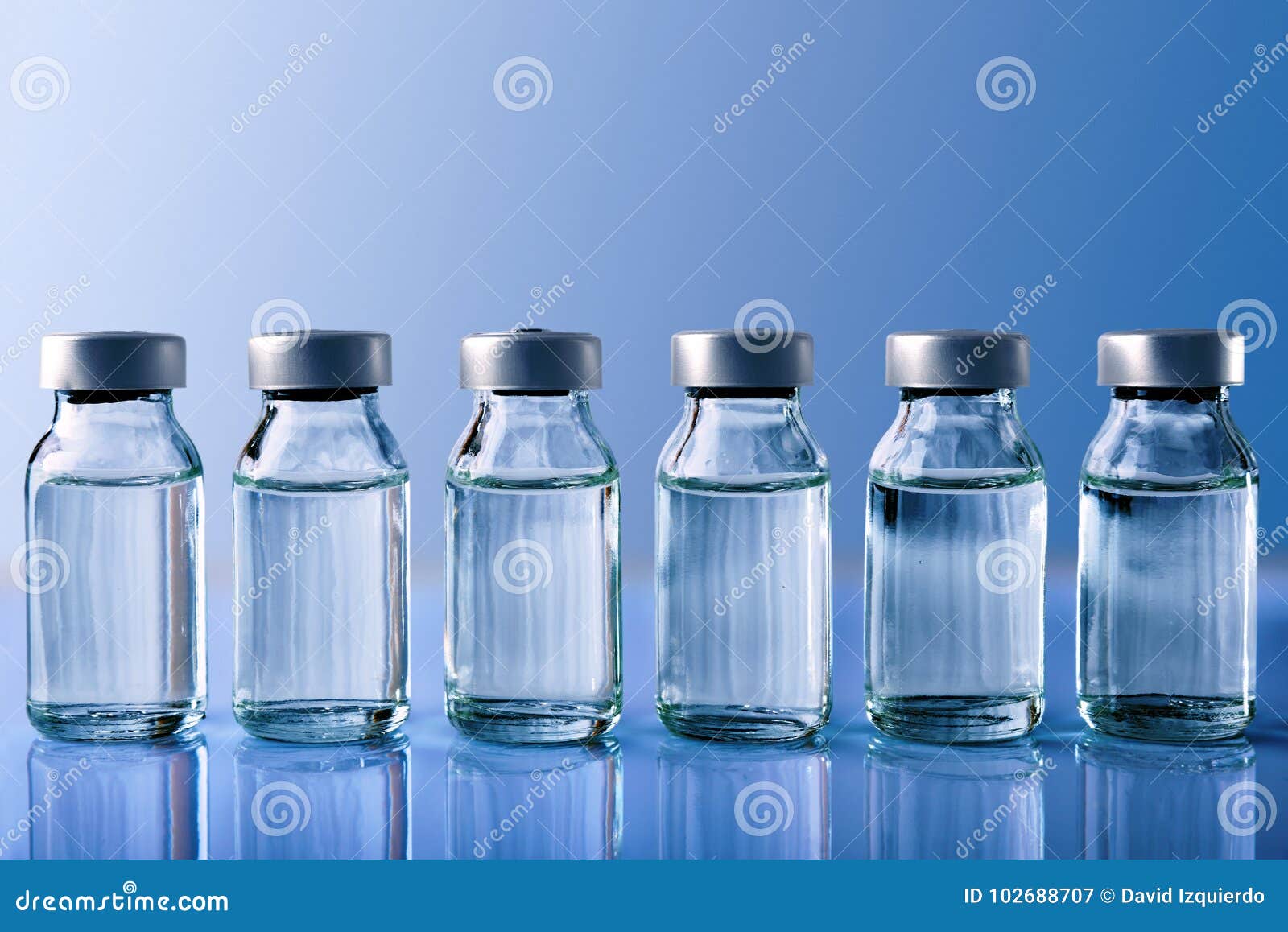 Row of Vials on Blue Table and Blue Background Front View Stock Image ...