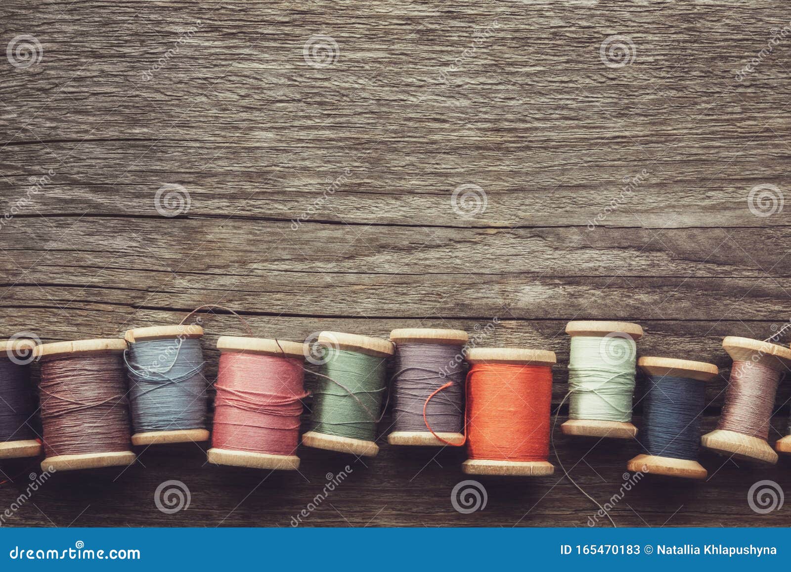 Row of Vintage Spools of Multicolored Threads on Wooden Board. View ...