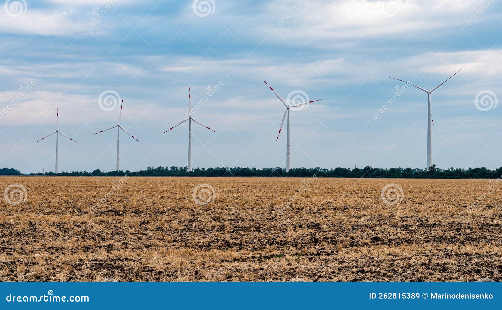 A Row of Windmills Wind Turbines with Rotating Blades Against the ... A Row of Windmills Wind Turbines with Rotating Blades Against the ...