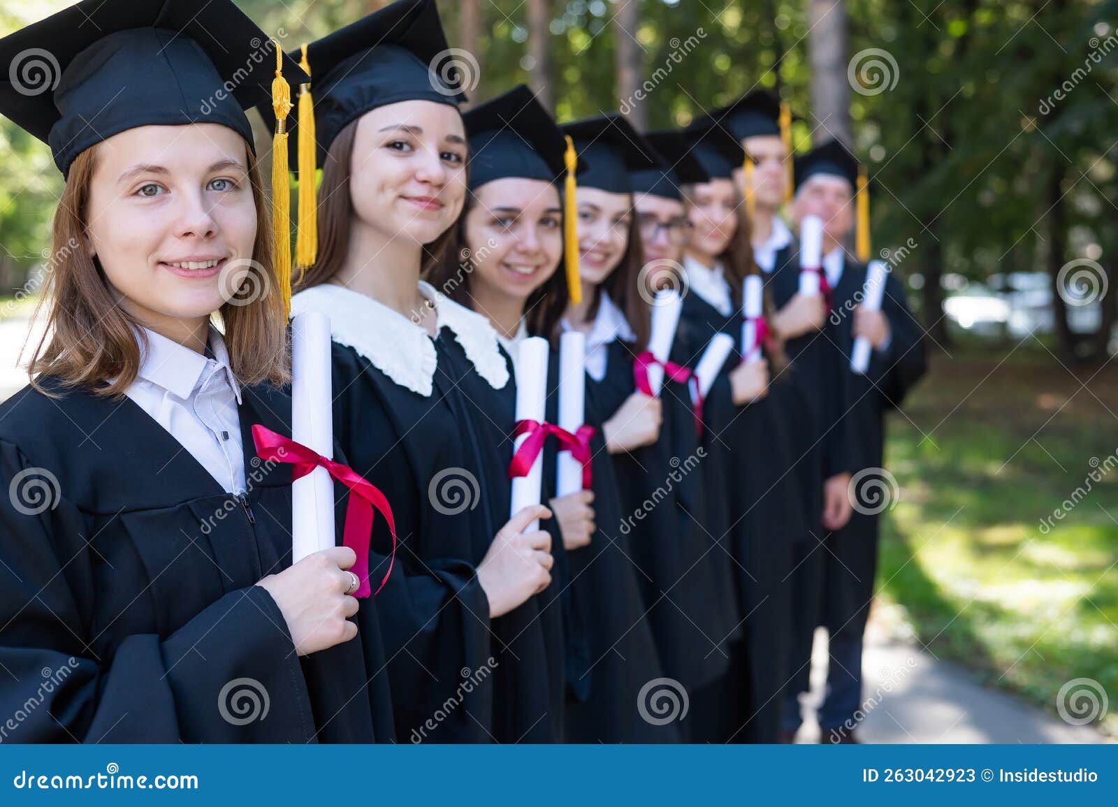 Row of Young People in Graduation Gowns Outdoors. Age Student. Stock ...