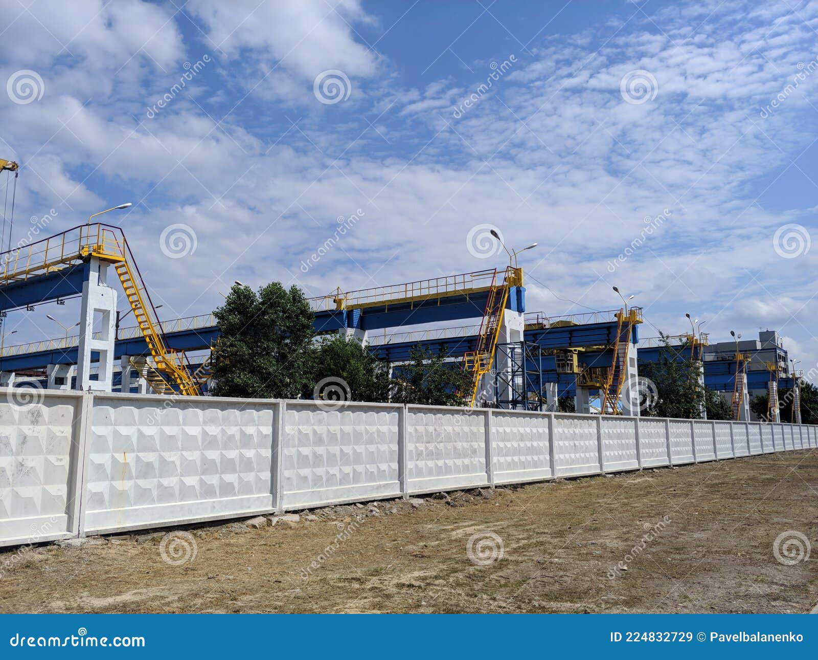 Rows of Industrial Cargo Cranes Behind White Fence Stock Image - Image ...