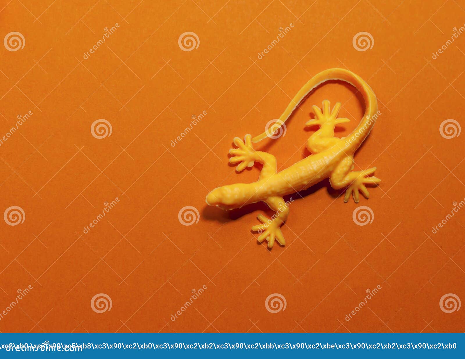 Rubber Yellow Lizard on a Bright Contrasting Orange Background Stock ...