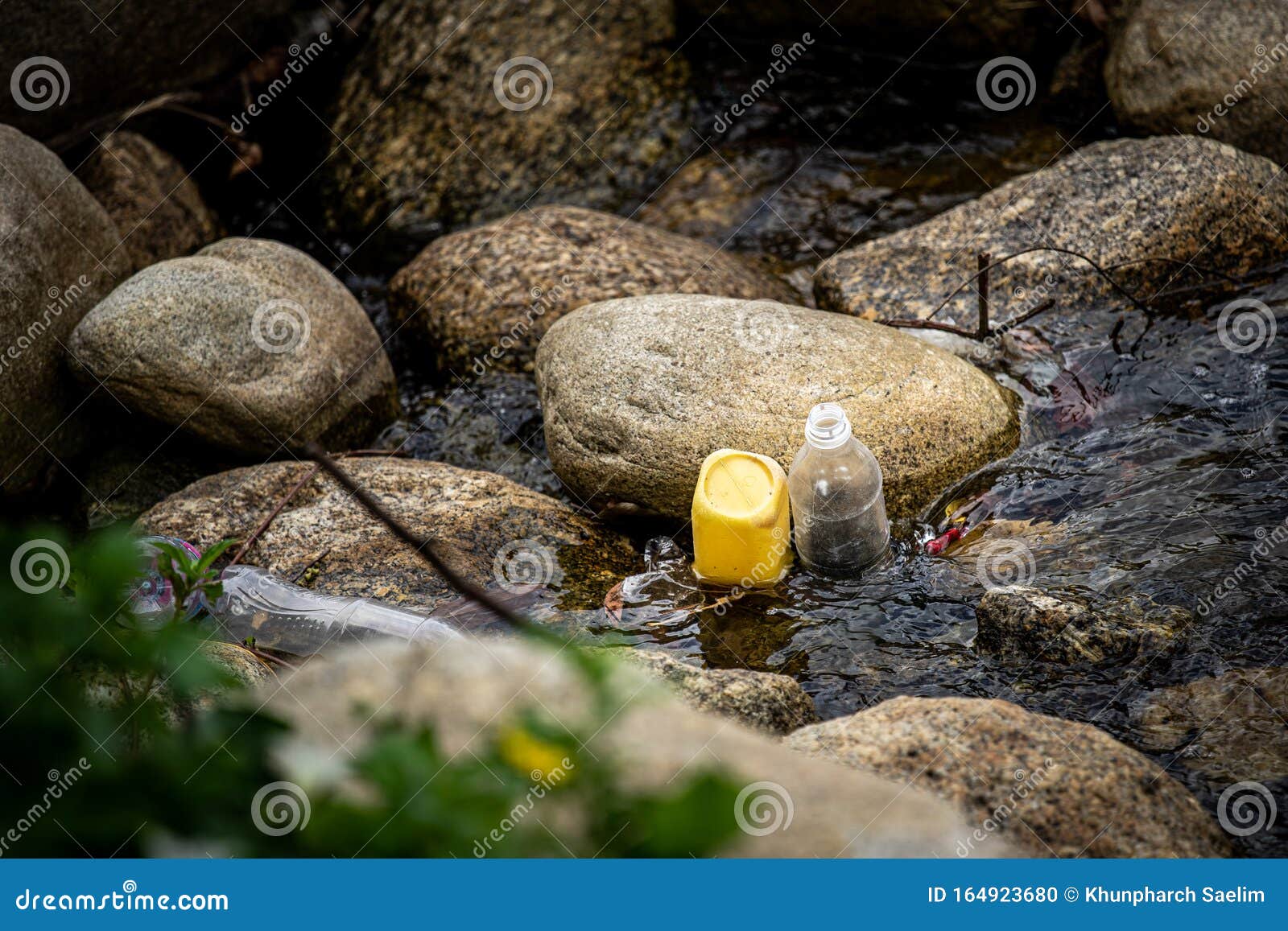 Rubbish Plastic Bottles in the River that Has Rocks Stock Photo - Image ...