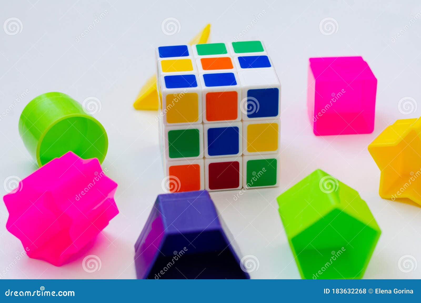 Rubik`s Cube and Different Game Color Pieces on a White Background ...