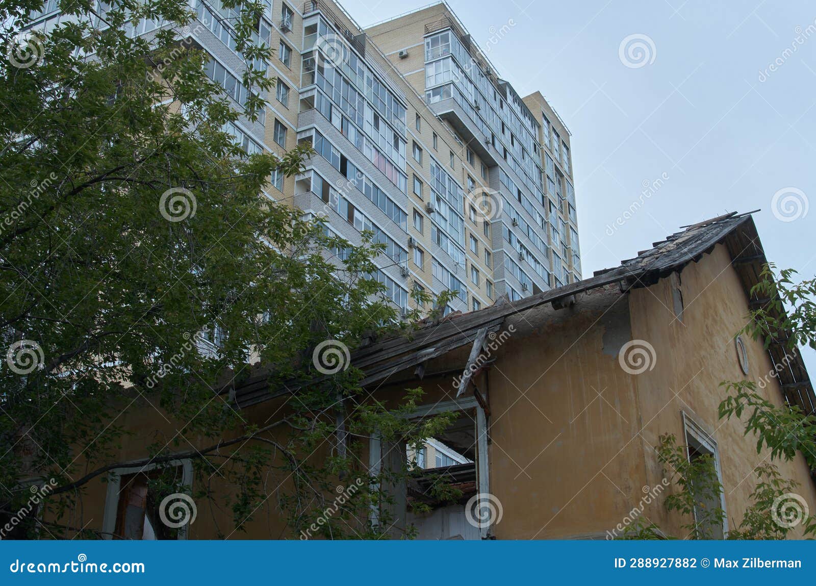 The Ruins of an Old House Against the Backdrop of a Modern Brick High ...