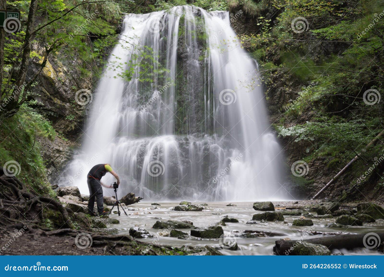 Rushing Waterfall in the Forest with a Photographer Capturing the View ...