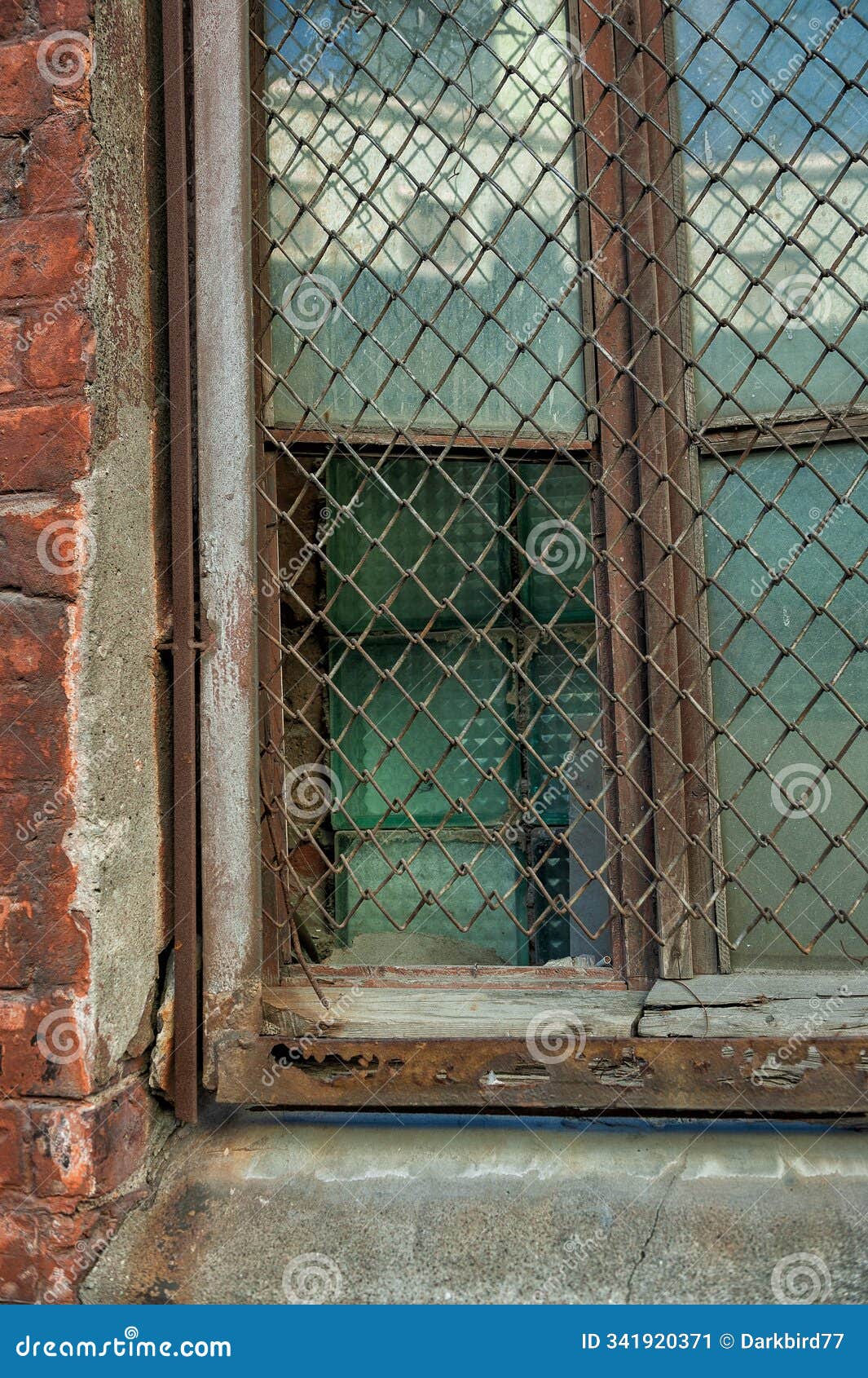Rusted Metal Grid Guards a Weathered Glass Window in an Old Structure ...