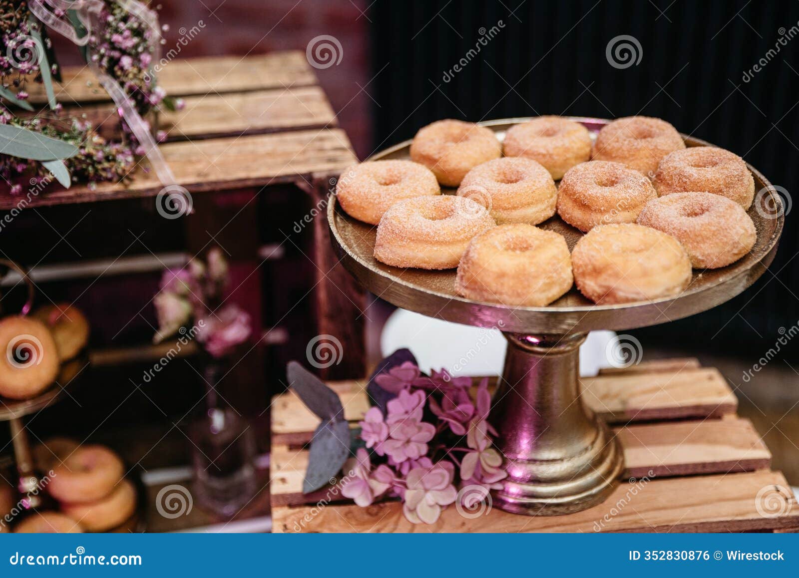 Rustic Display of Sugar-coated Donuts on a Metal Stand with Floral ...
