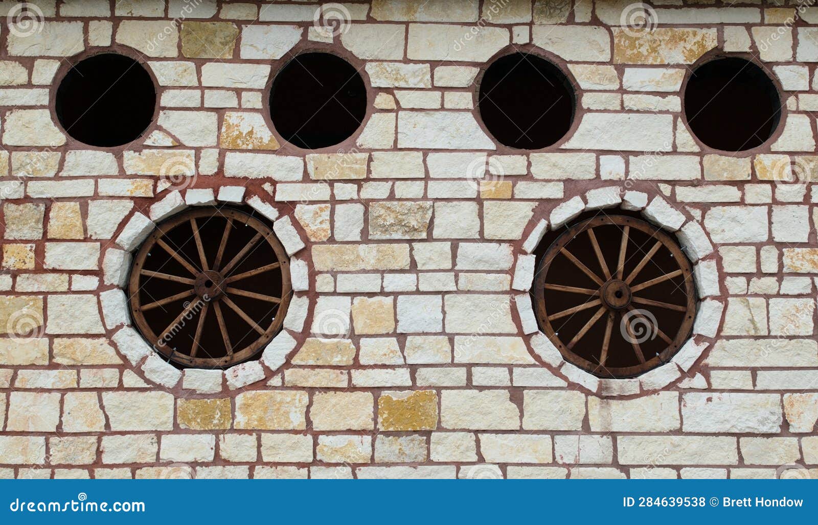 Rustic Feature Stone Wall with Wagon Wheels and Round Portals Inside ...