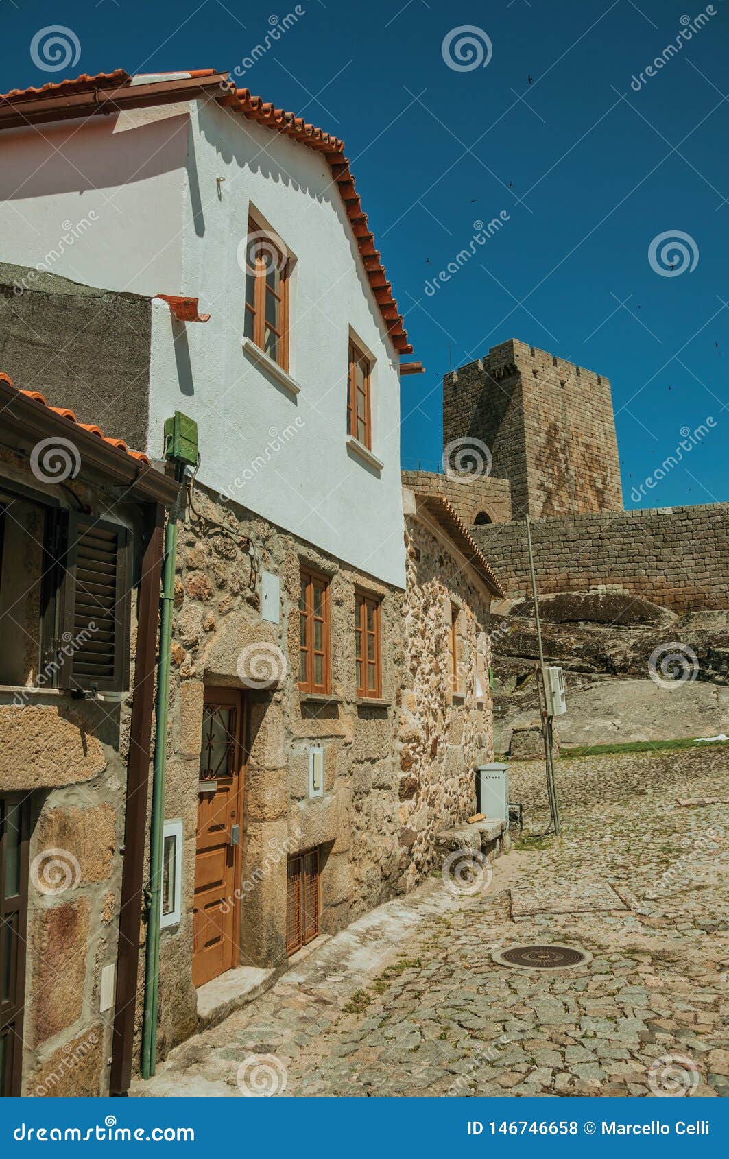 Rustic House in Front of Stone Wall and Square Tower Stock Photo ...