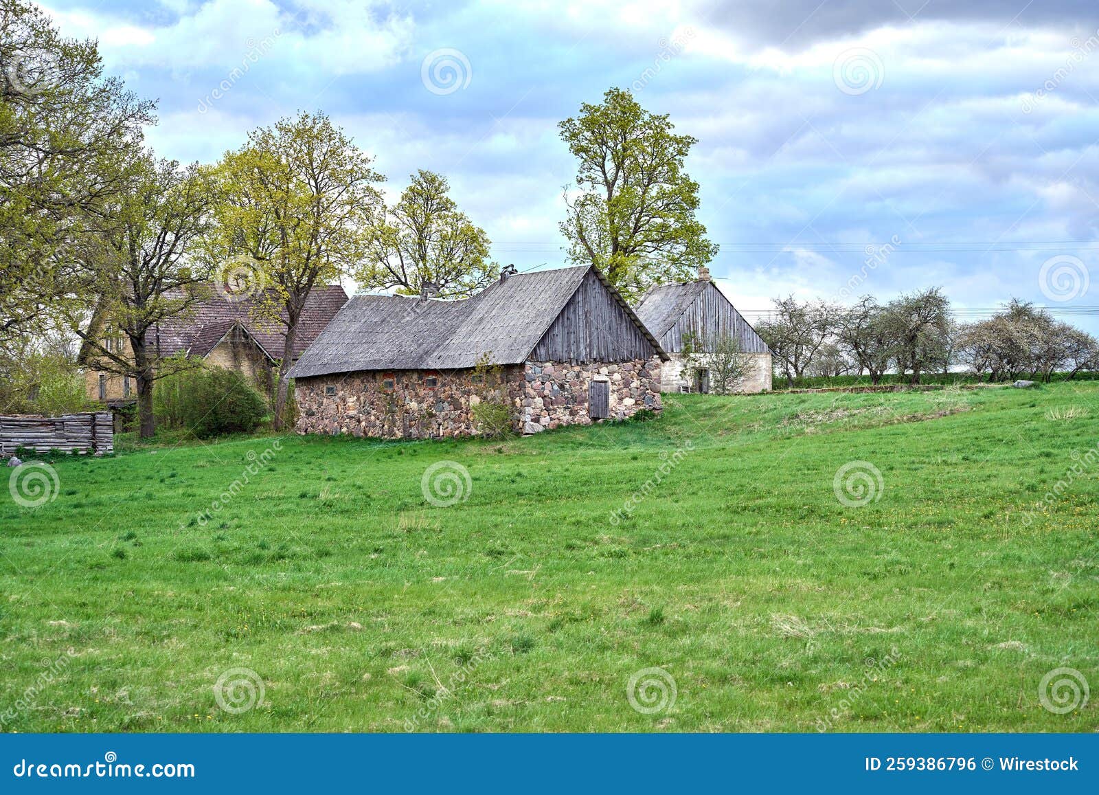 Rustic Stone Building with Trees, a House and a Cloudy Sky in the ...