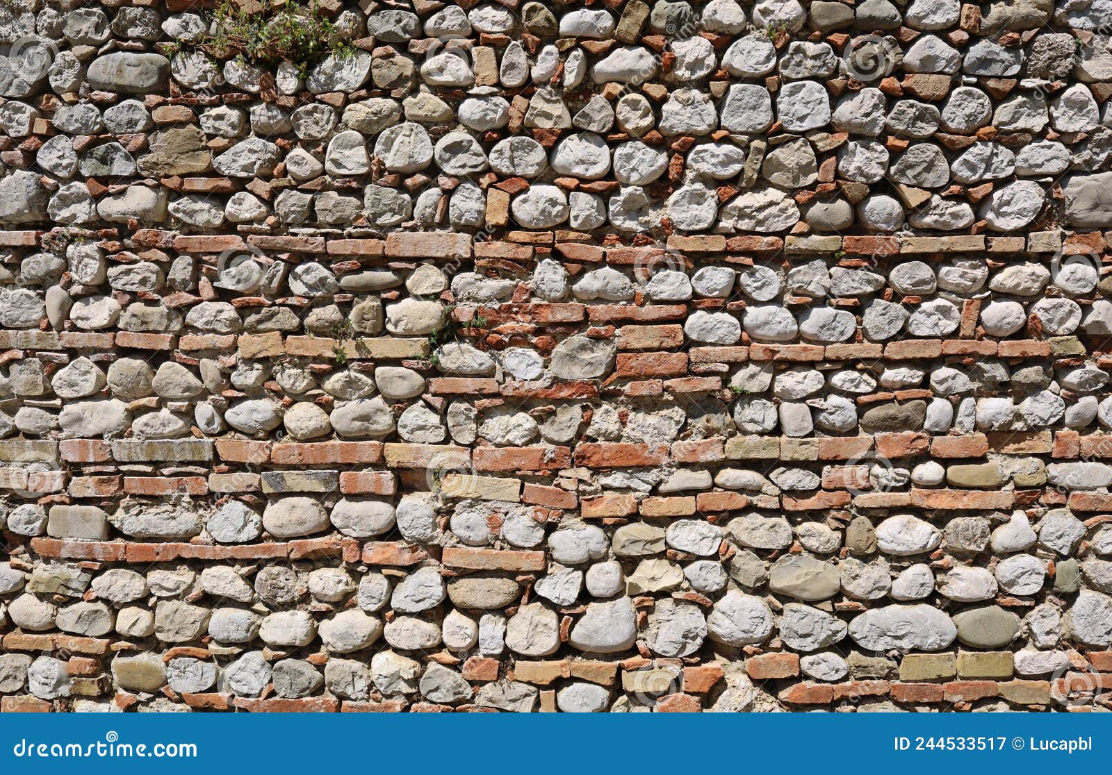 Rustic Stone Wall Made of Round White Rocks and Strips of Bricks. Stock ...