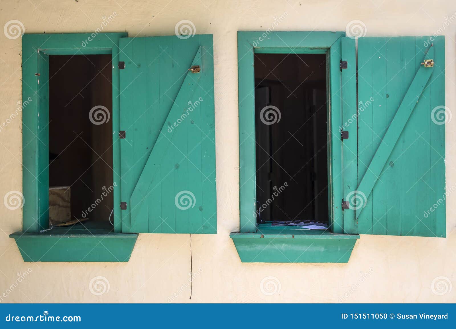 Rustic Ticket Booth Windows with Open Turquoise Shutters in Stucco Wall ...
