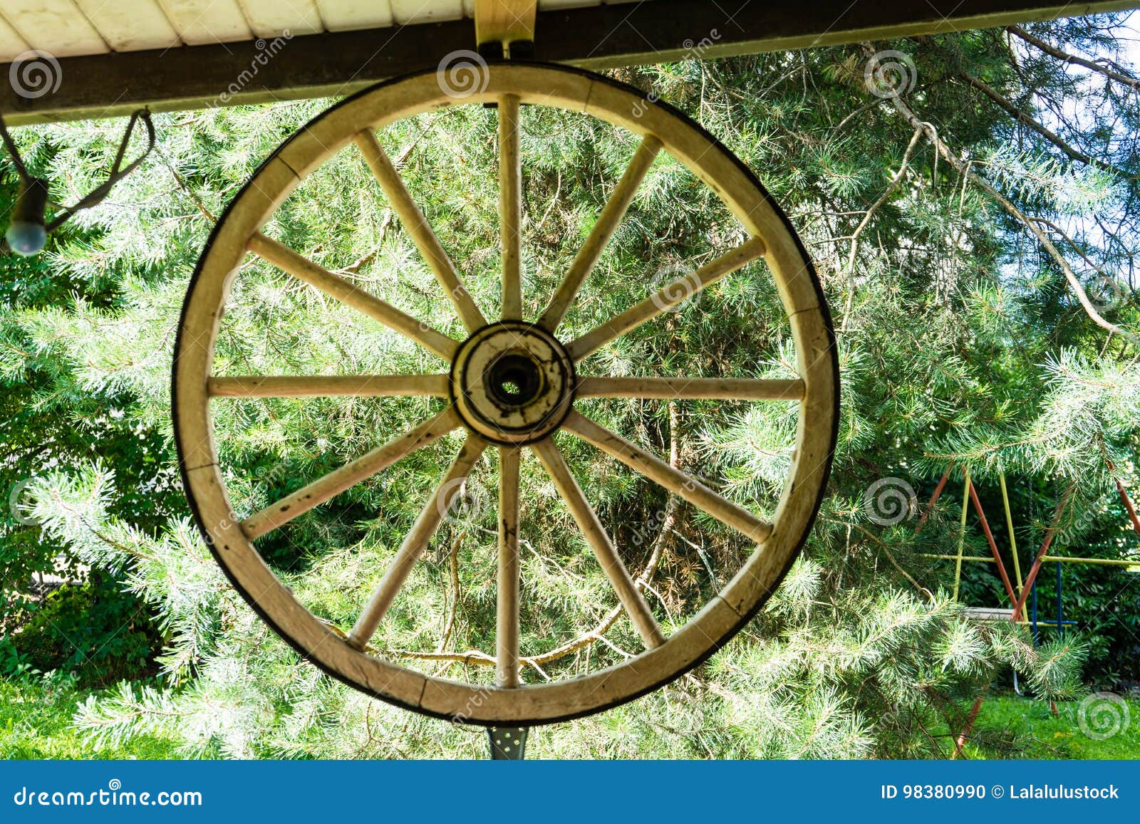 Rustic Wagon Wheel Hanging on a Wall in Garden Stock Photo - Image of ...