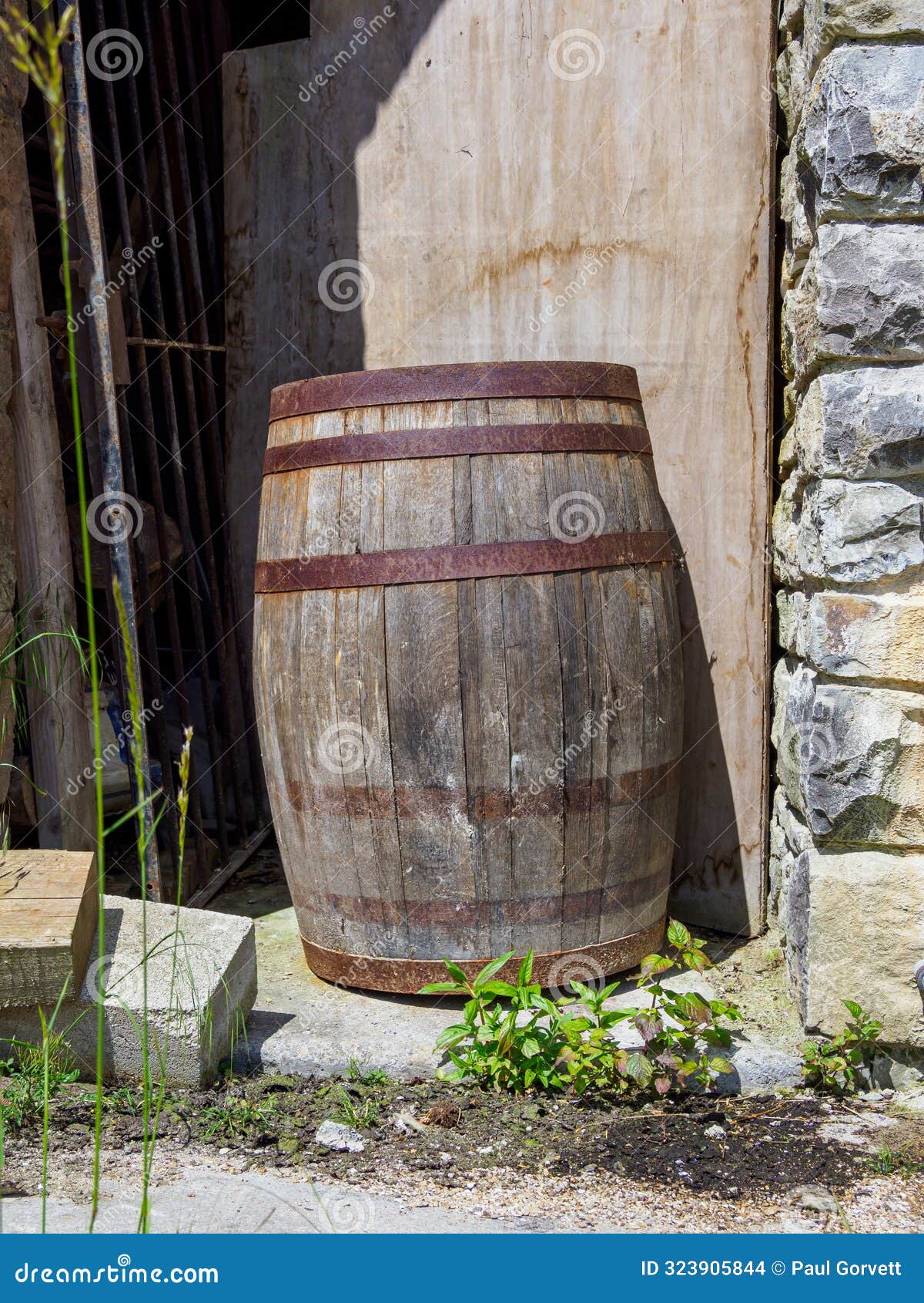 Rustic Wooden Barrel Against a Weathered Wall and Stone Structure on a ...