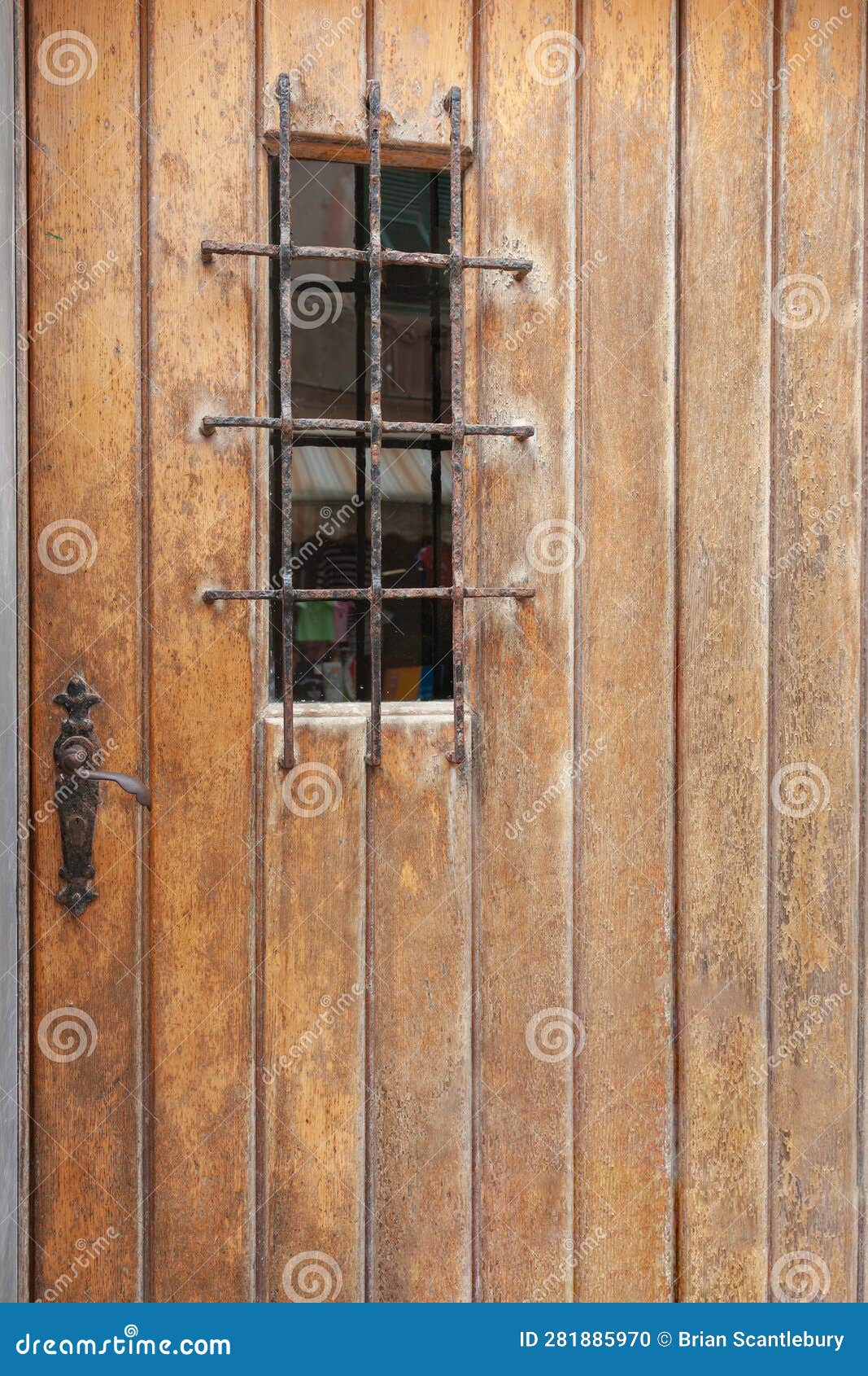 Rustic Wooden Door with Rusty Handle and Security Grille Stock Photo ...