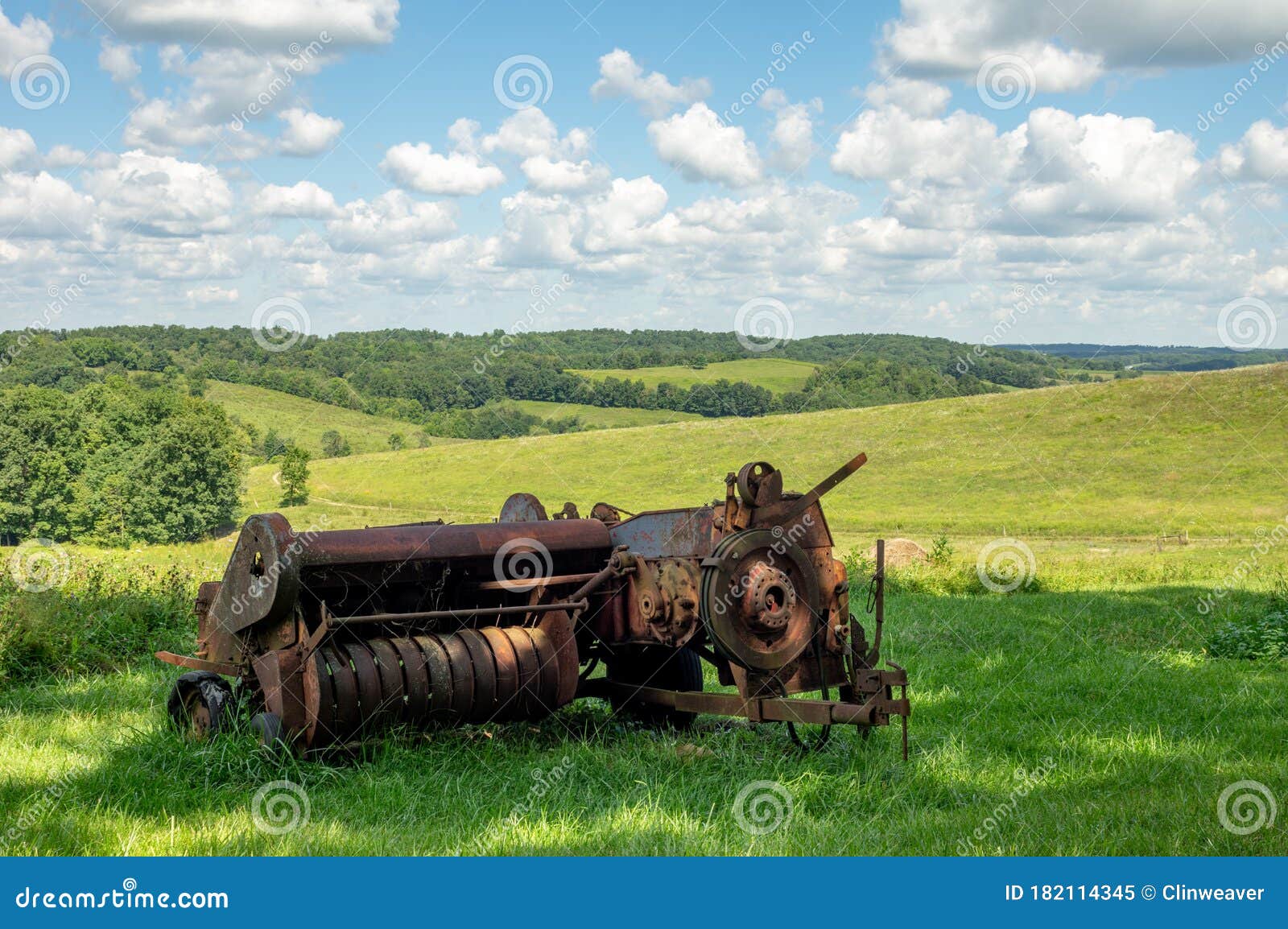 Rusty Baler with Rolling Hills in the Background Stock Image - Image of ...