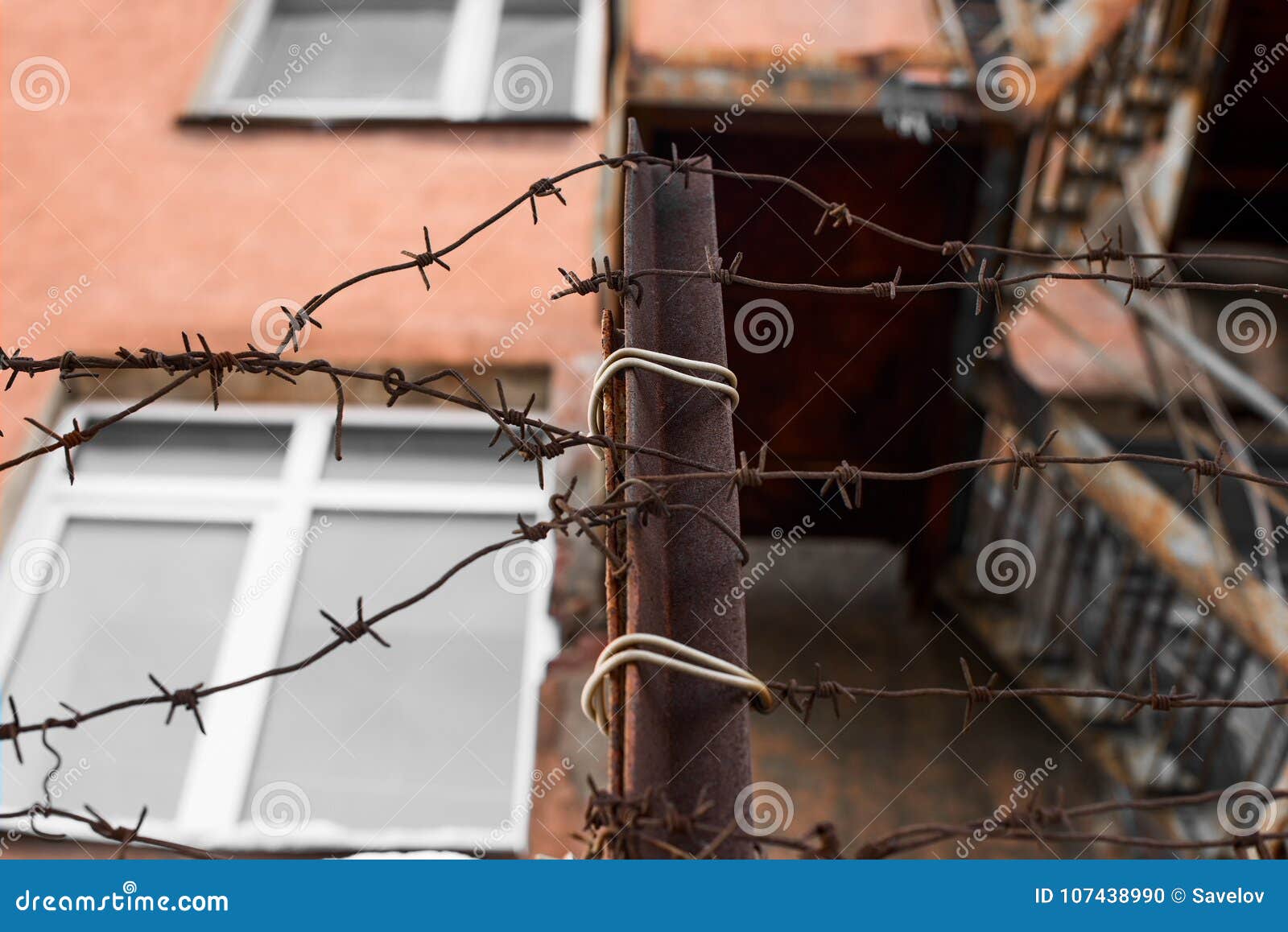 Rusty Barbed Wire and a Building with Windows and Stairs Stock Photo ...