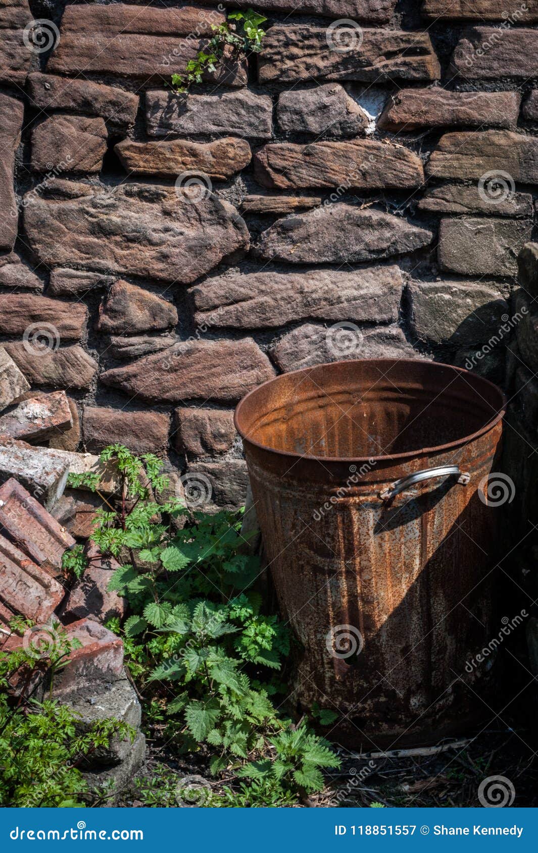 Rusty Bin by Stone Wall stock image. Image of broken - 118851557