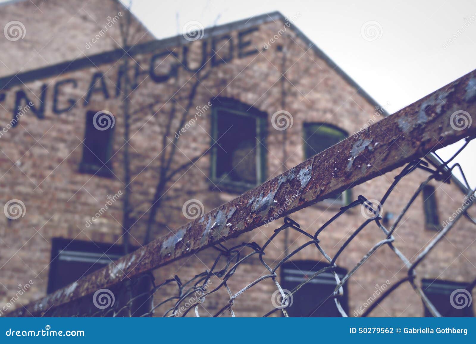 Rusty Fence in Front of Old Brick Building Stock Photo - Image of ...