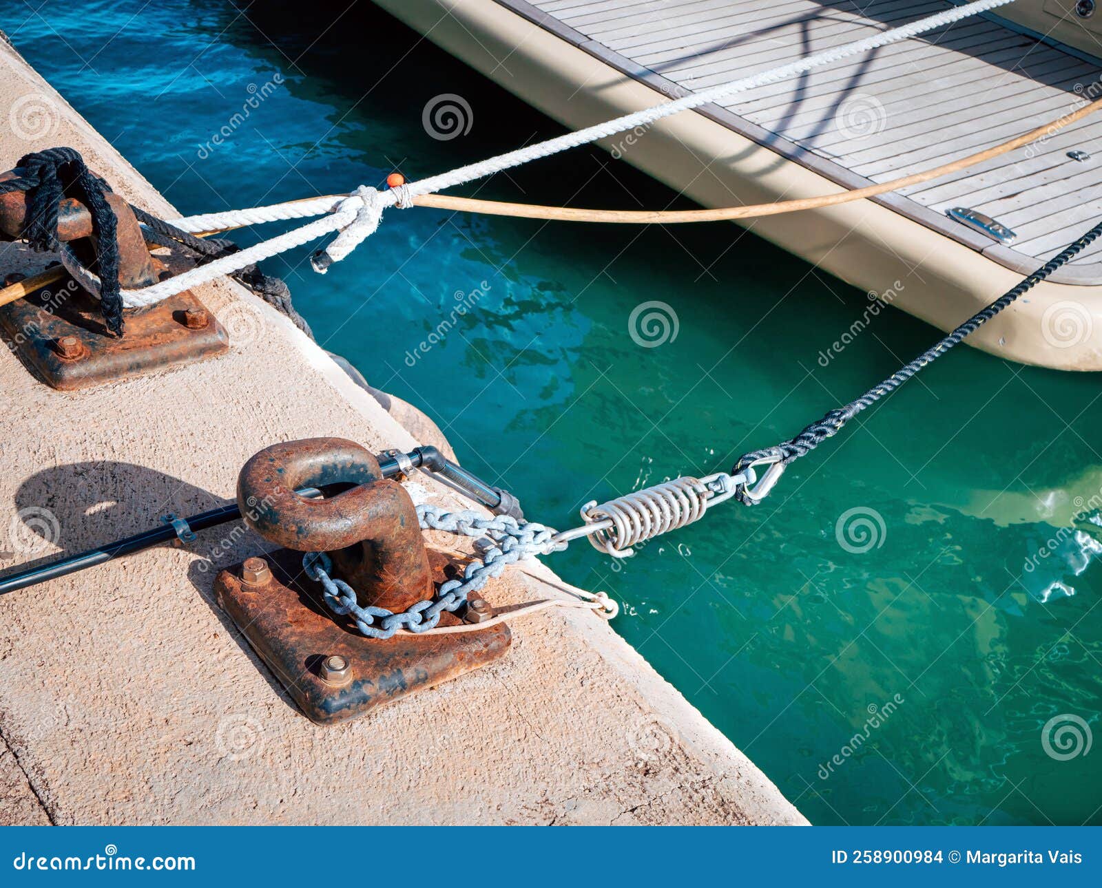 Rusty Mooring Bollards with Chains and Ropes Tied To Them in a Harbour ...