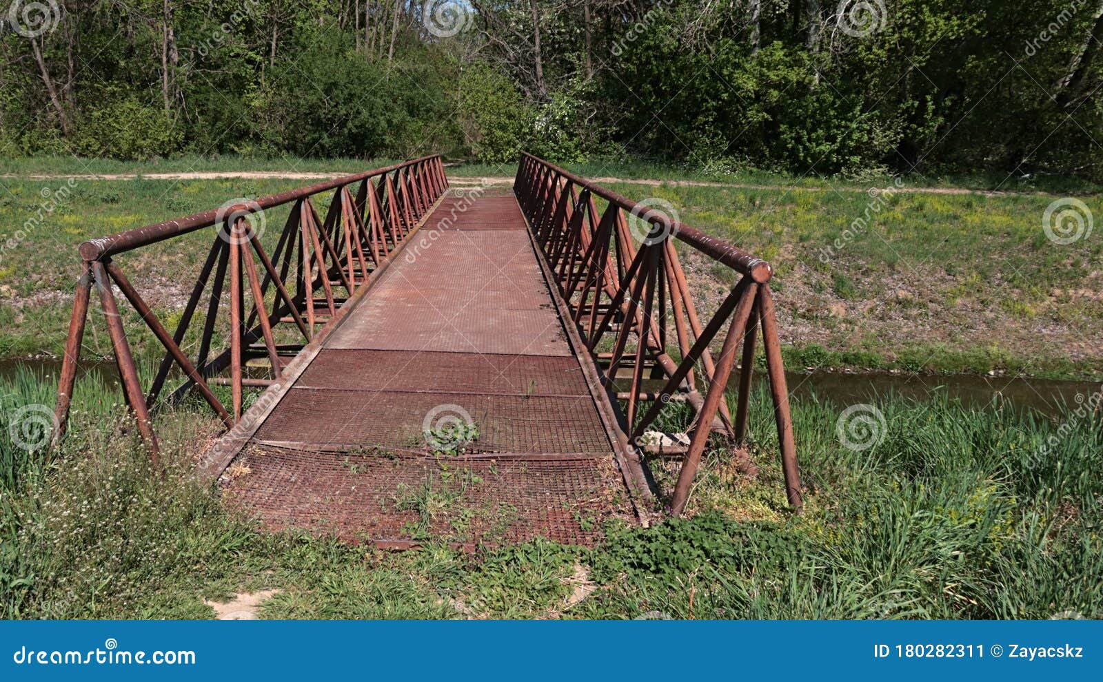 Rusty Pedestrian Bridge with Grate Floor As Pathway Across Artificial ...
