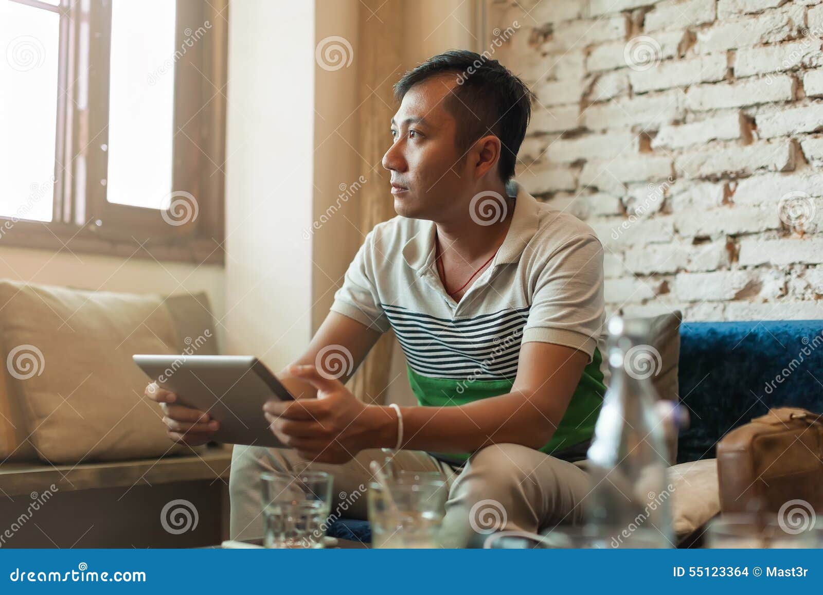 Sad Asian Man Using Tablet Computer Sitting at Stock Photo - Image of ...