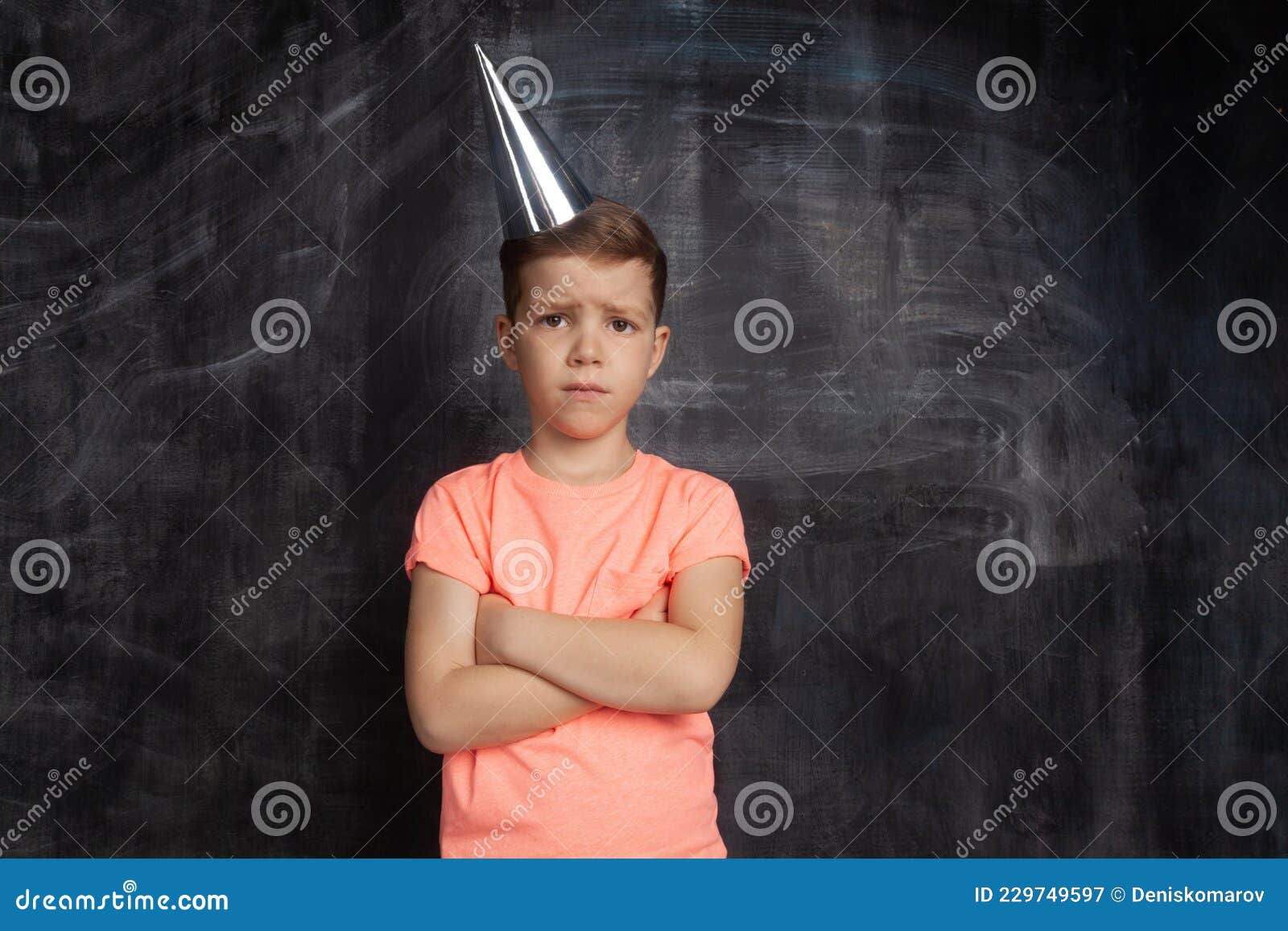 Frowning Grumpy Teen Boy Standing With Folded Arms Over Blue Background ... Frowning Grumpy Teen Boy Standing With Folded Arms Over Blue Background ...