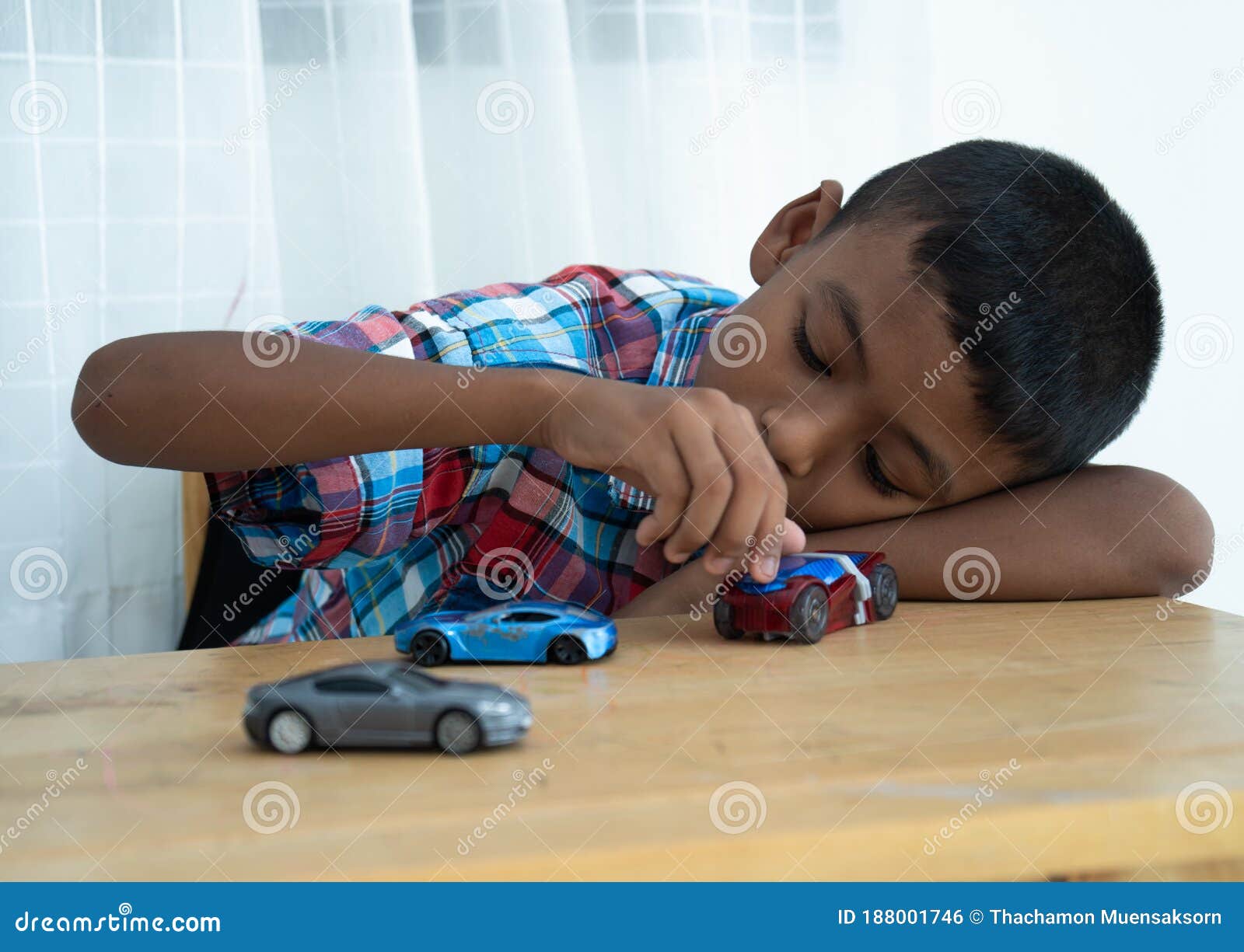 Sad Little Boy Lying on the Table and Play Toy Car Stock Photo - Image ...