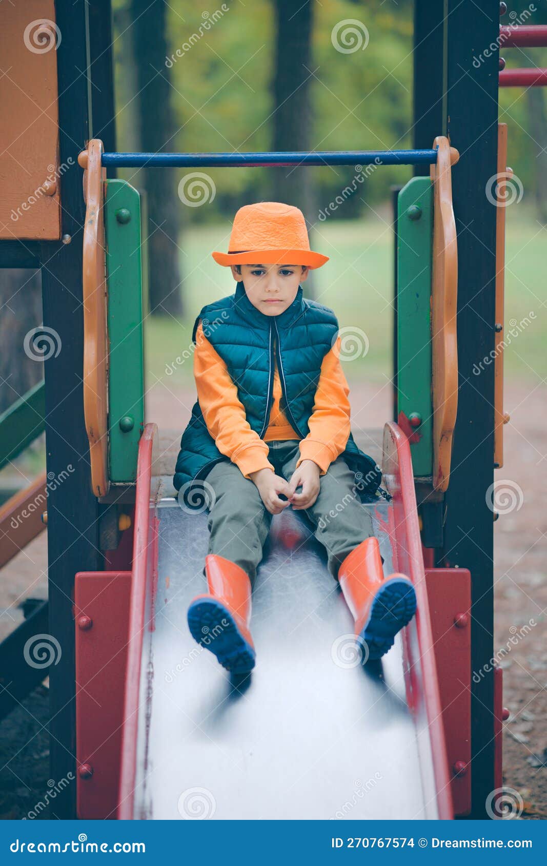A Sad Child in the Playground on the Slide in the Fall Stock Photo ...