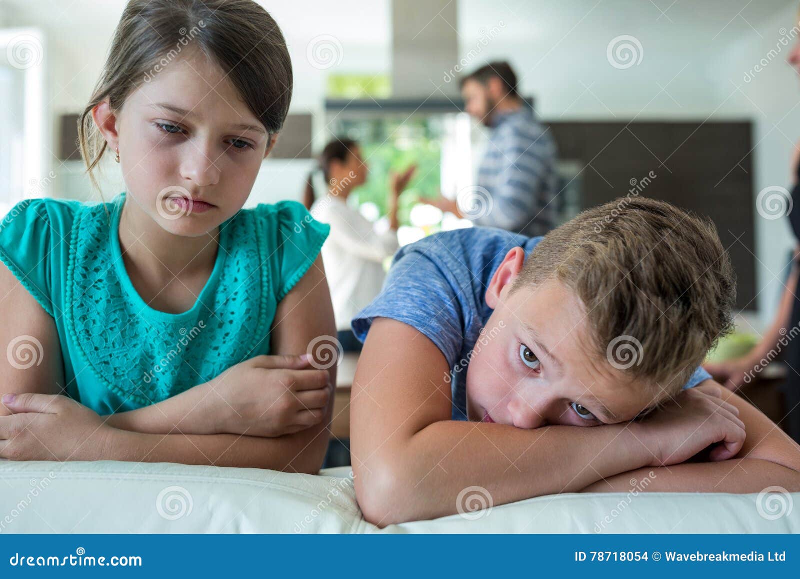 Sad Kids Leaning on Sofa while Parents Arguing in Background Stock ...