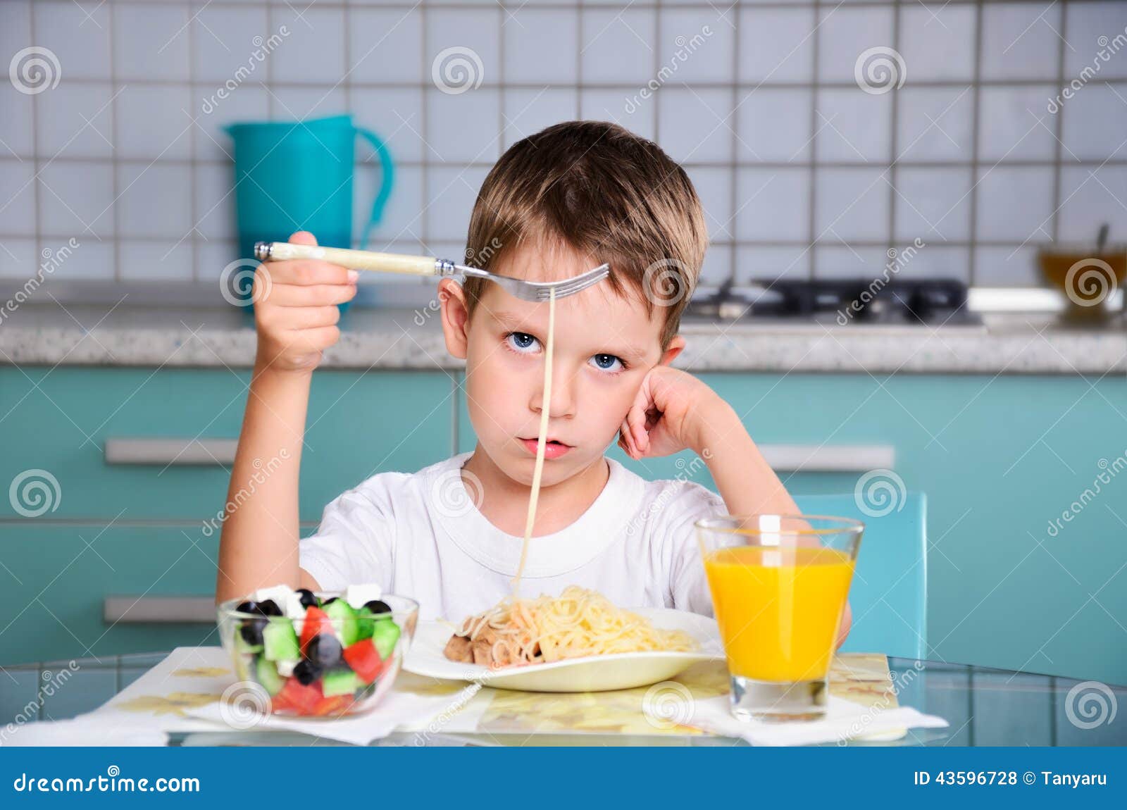Sad Little Boy Sits at the Dining Table and Looking Spaghetti Stock ...