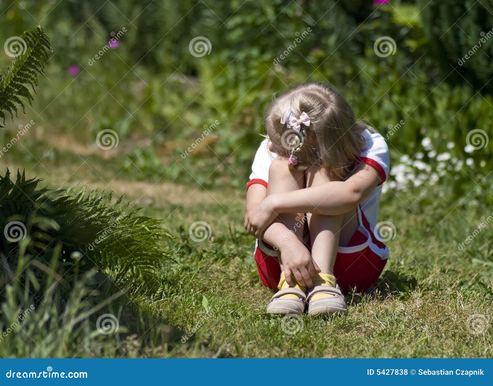 Sad little girl in garden stock photo. Image of holding - 5427838