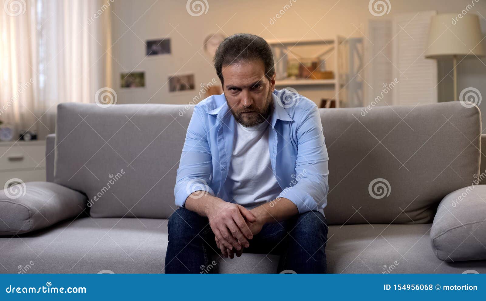 Sad Lonely Man Aggressively Looking into Camera Sitting on Sofa at Home ...