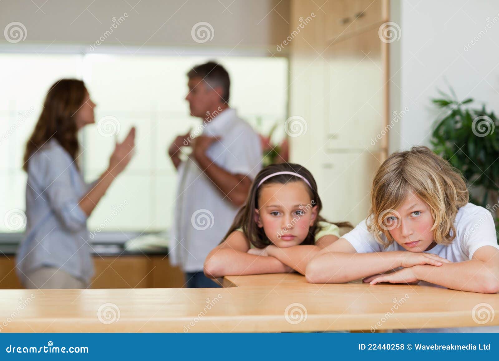 Sad Looking Siblings with Arguing Parents Behind Them Stock Photo ...