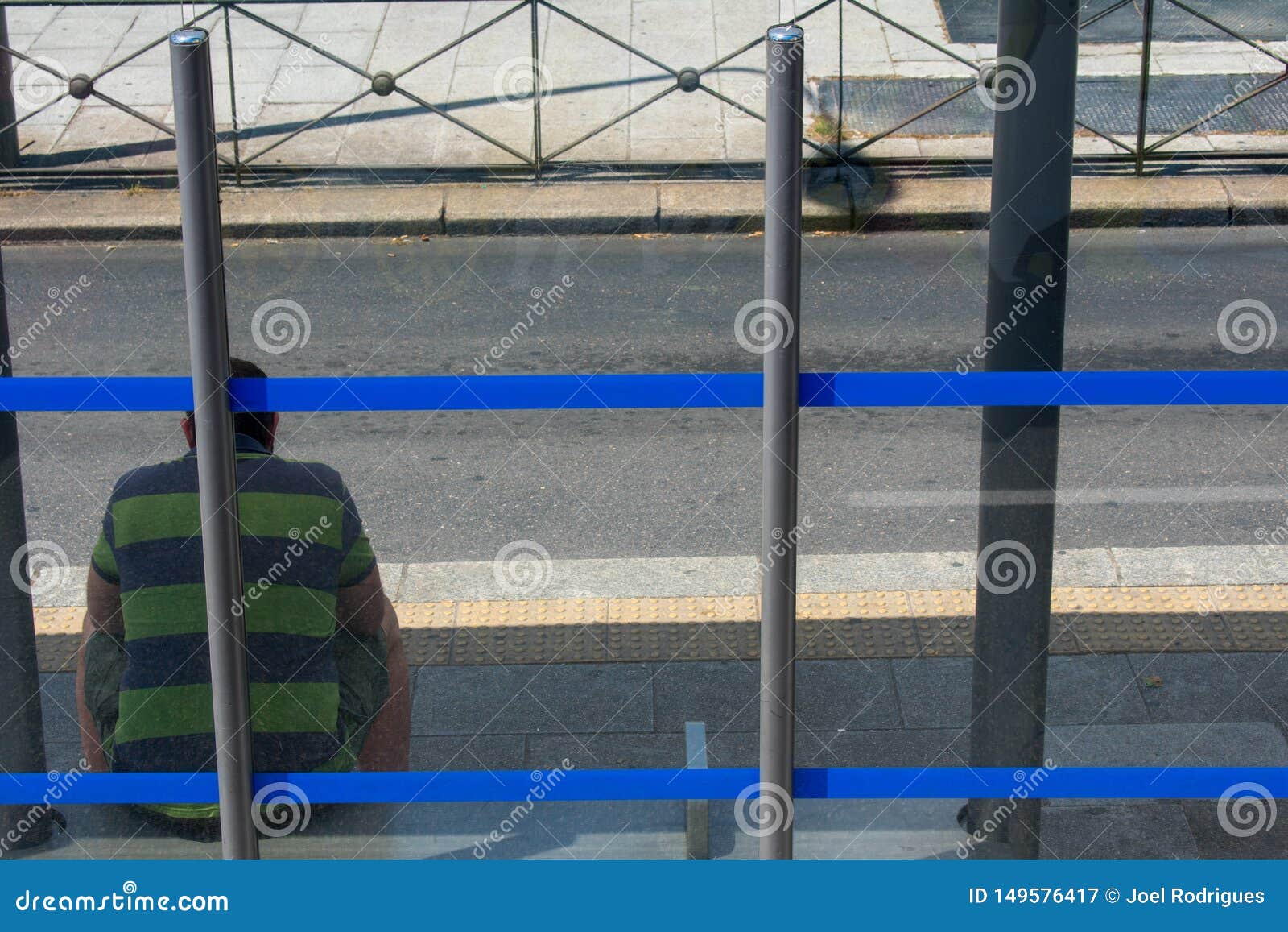 Sad Man Sitting at Blue Stripped Bus Stop on Sunny Day Stock Image ...
