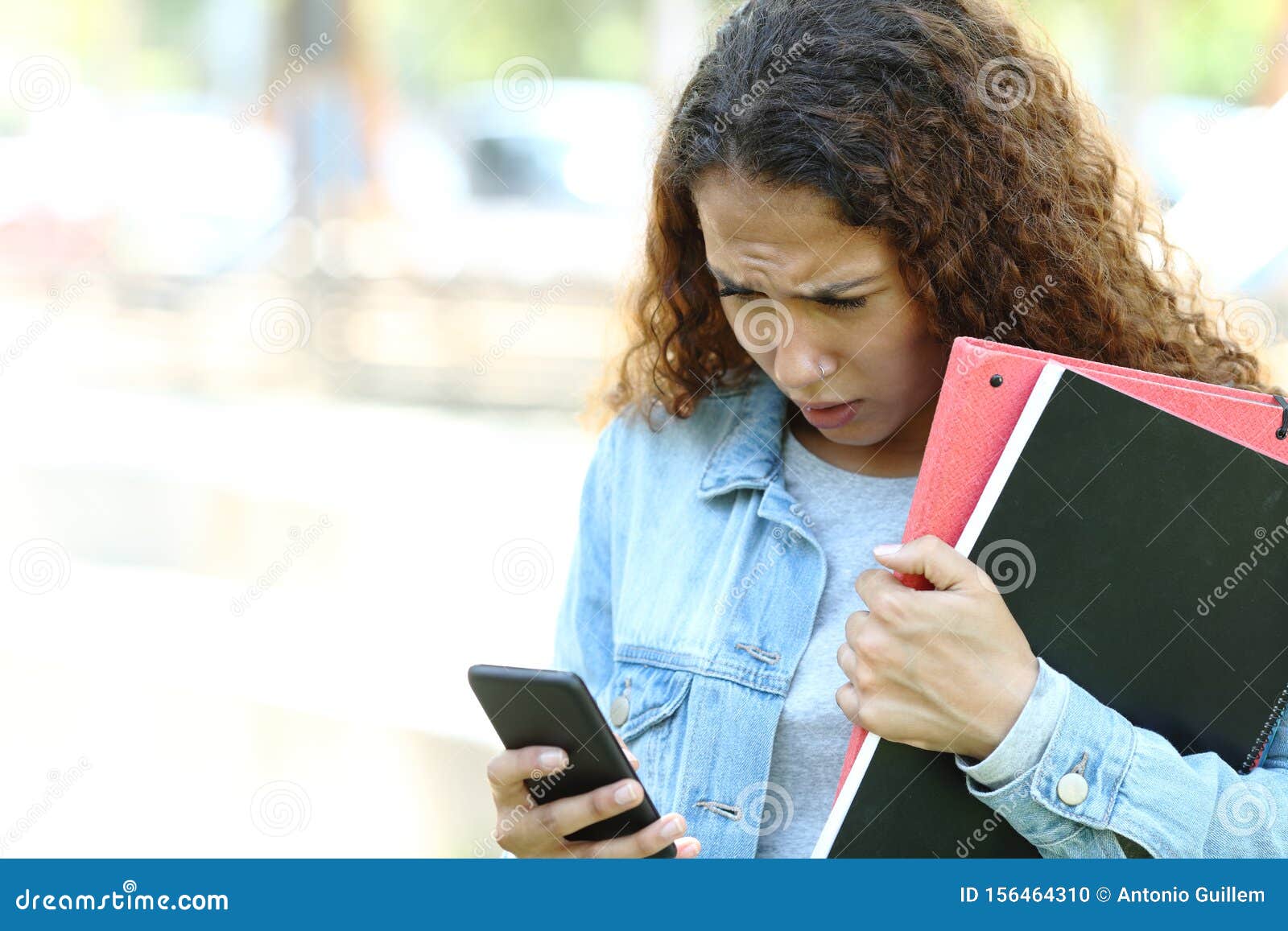Sad Mixed Race Student Checking Phone Messages Stock Photo - Image of ...