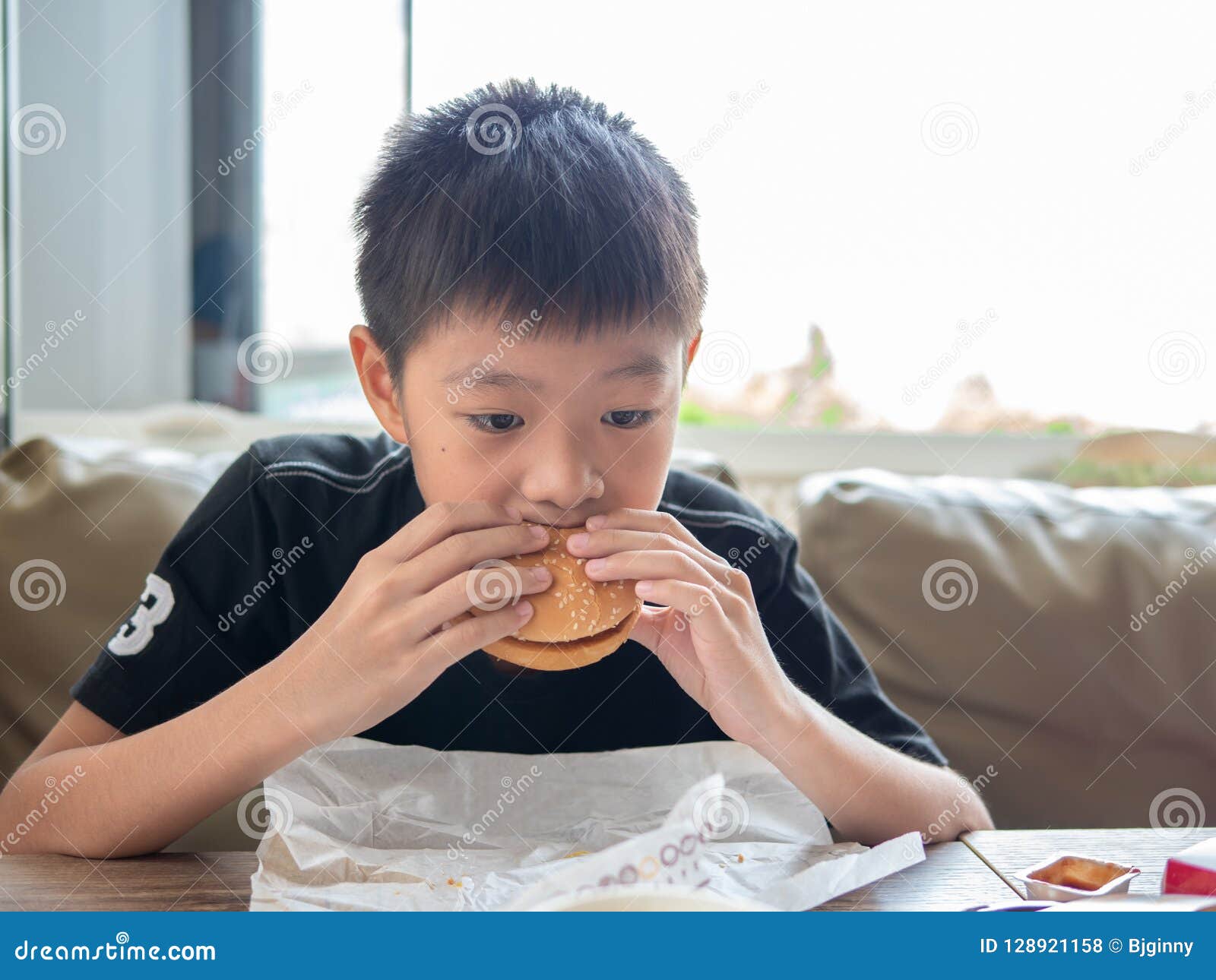 A Sad Moody Boy Eating Hamburger Stock Photo - Image of restaurant ...