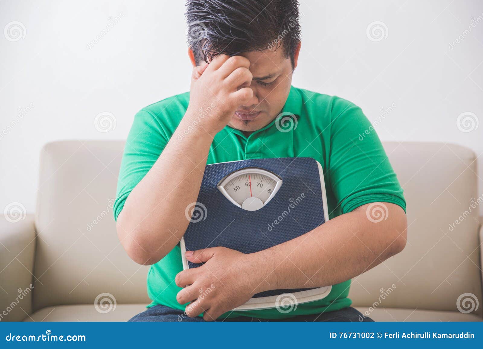 Sad Obese Man Holding a Weight Scale, Thinking about His Weight Stock ...