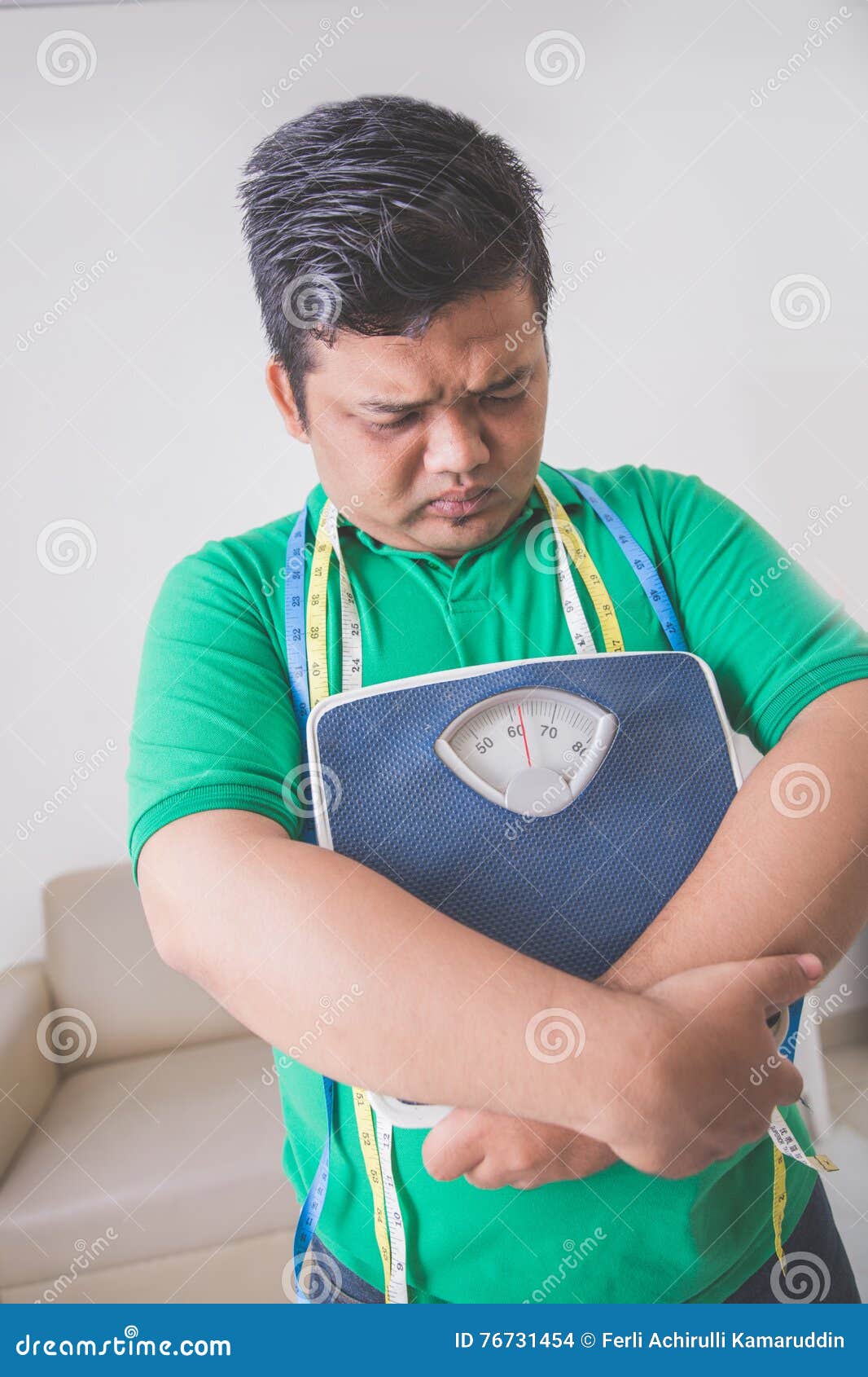 Sad Obese Man Holding a Weight Scale, Thinking about His Weight Stock ...