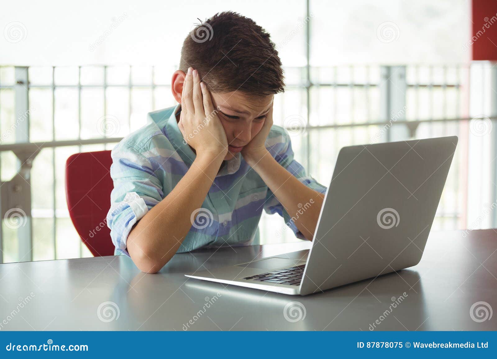 Sad Schoolboy Looking at Laptop in Library Stock Image - Image of ...