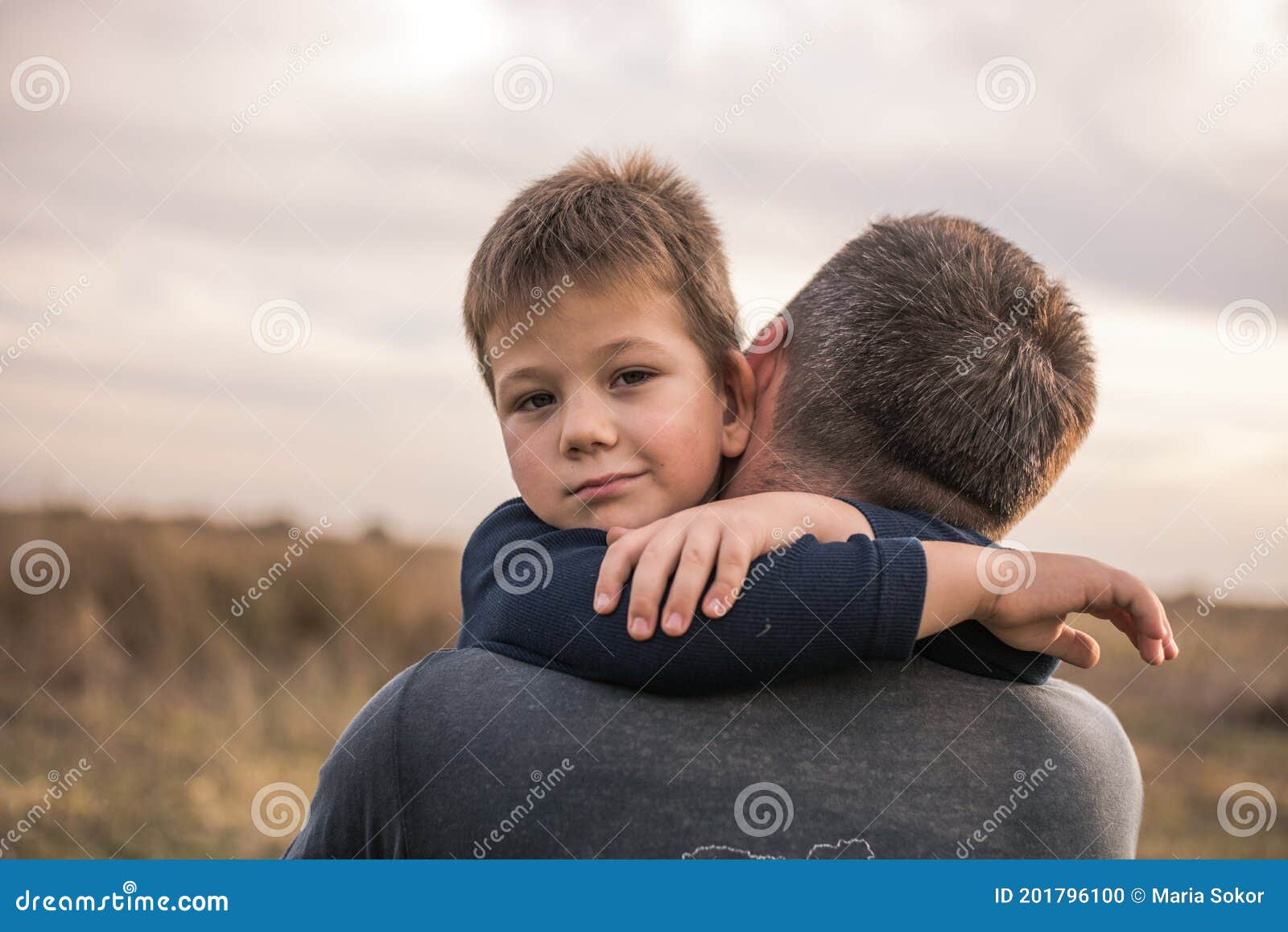 Sad Son Hugging Dad on the Meadow Background. Concept of Father-son ...