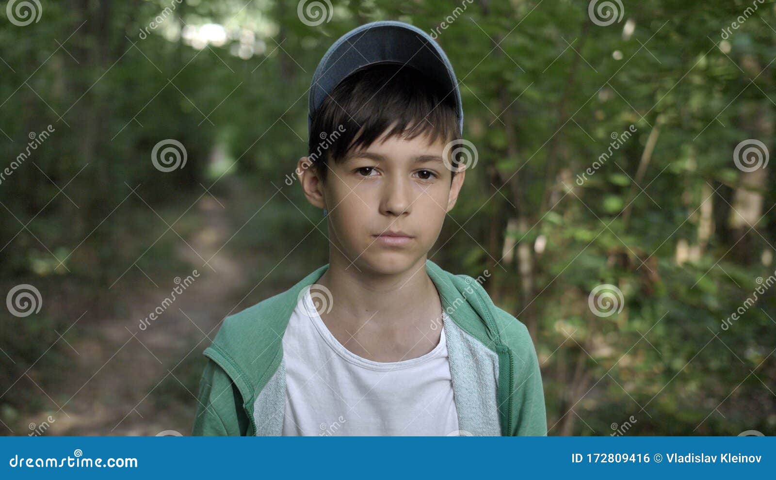 Sad Traveler Boy in a Cap in the Forest Looking at the Camera Stock ...