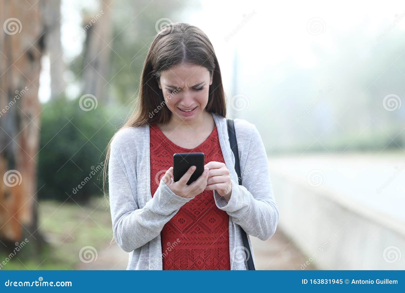 Sad Woman Crying Walking Using Mobile Phone in a Park Stock Image ...