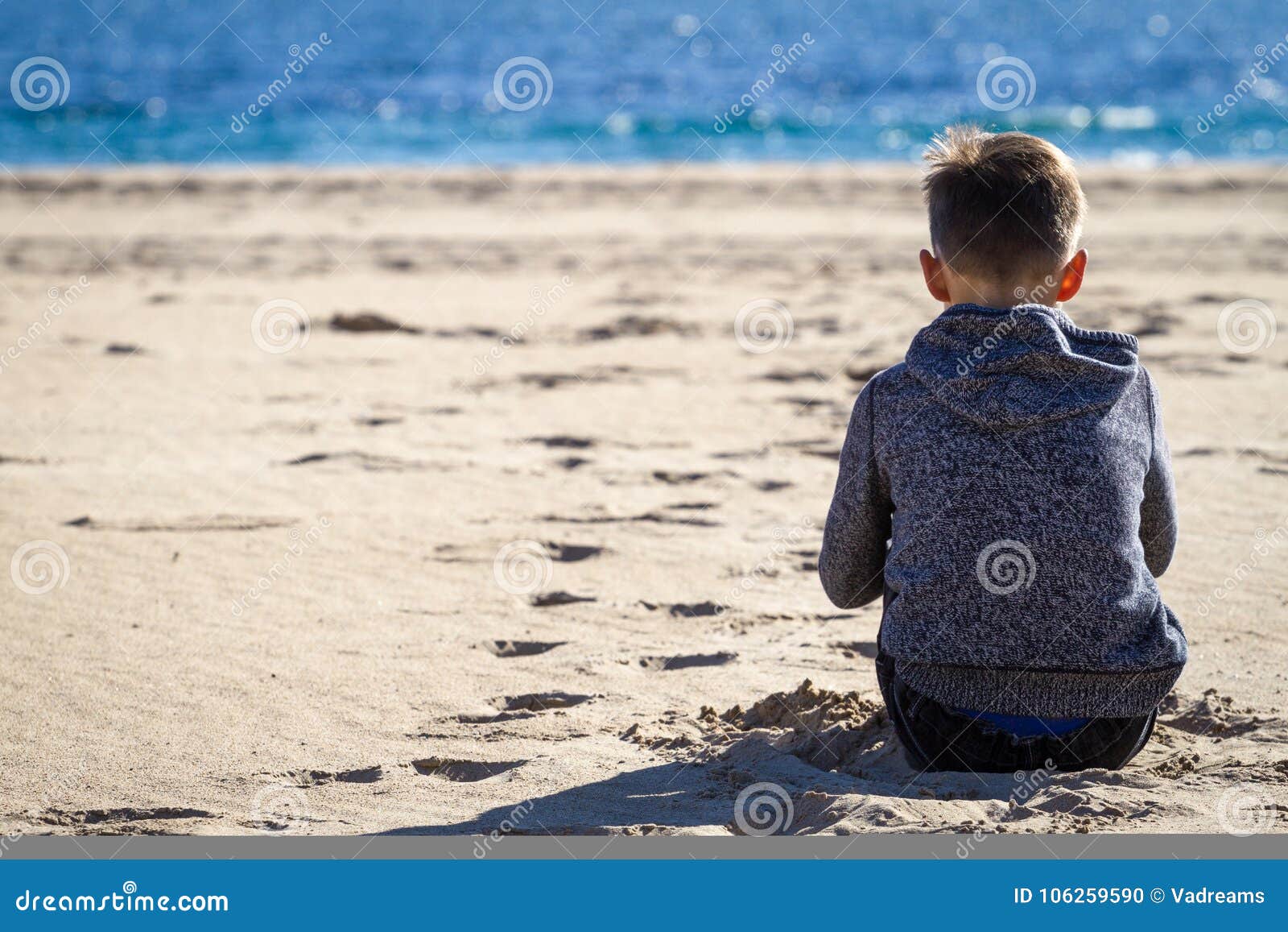 Sad Young Boy Sitting on the Beach, Looking at Sea and Thinking Stock ...