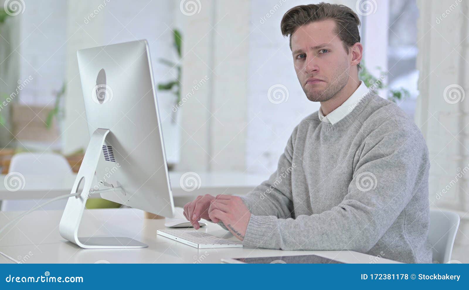 Sad Young Man Looking at Camera at Work Stock Photo - Image of ...