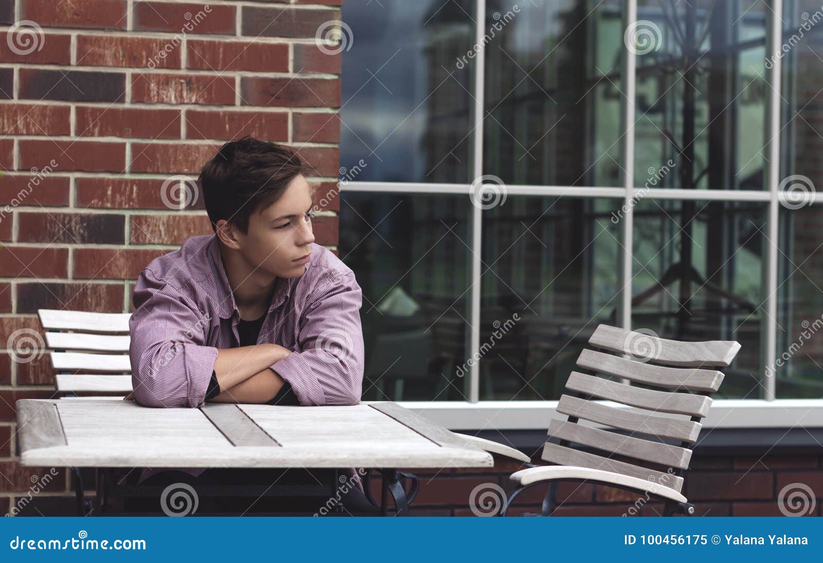 Sad Young Man Sitting at a Table Near a Wall Stock Image - Image of ...