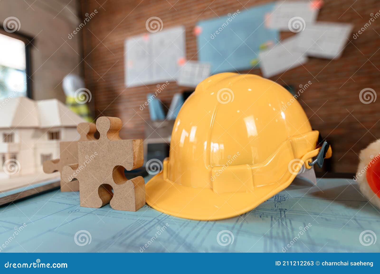Safety Helmets and Jigsaw on Design Plan on the Table at Site ...