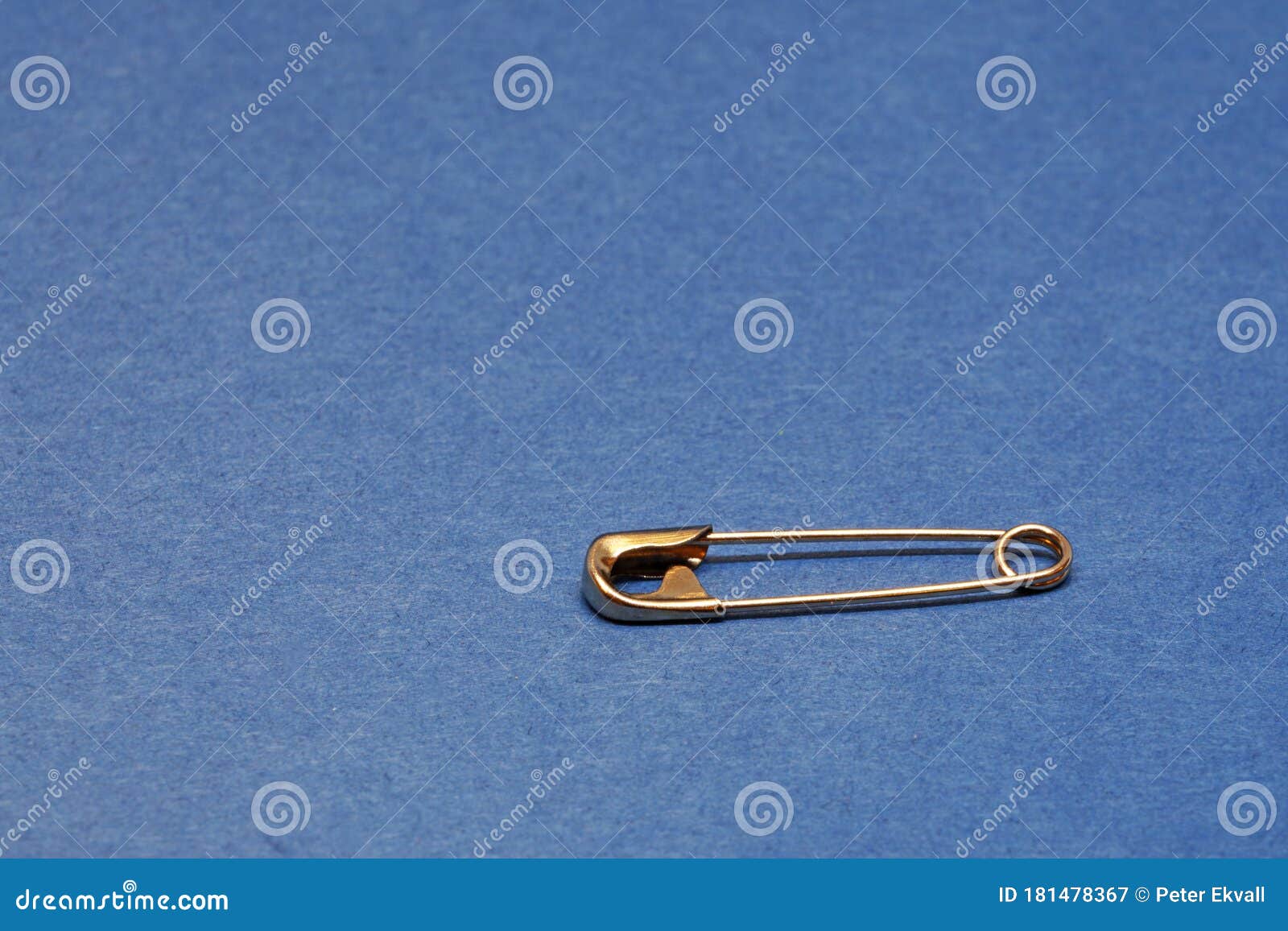 Safety Pin in Gold on Blue Background Stock Image - Image of material ...